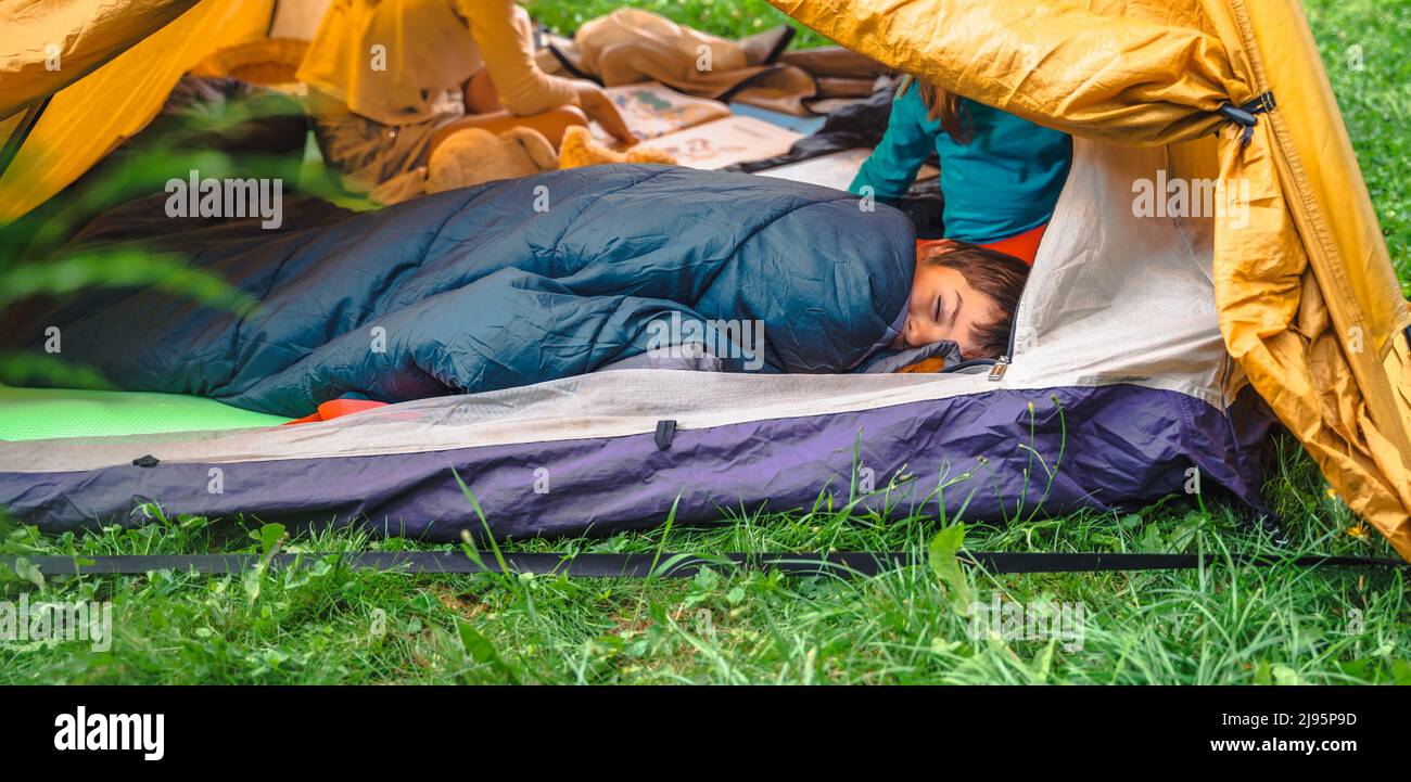 Small children, kids, boy play, sleep in sleepig bag in orange tourist ...