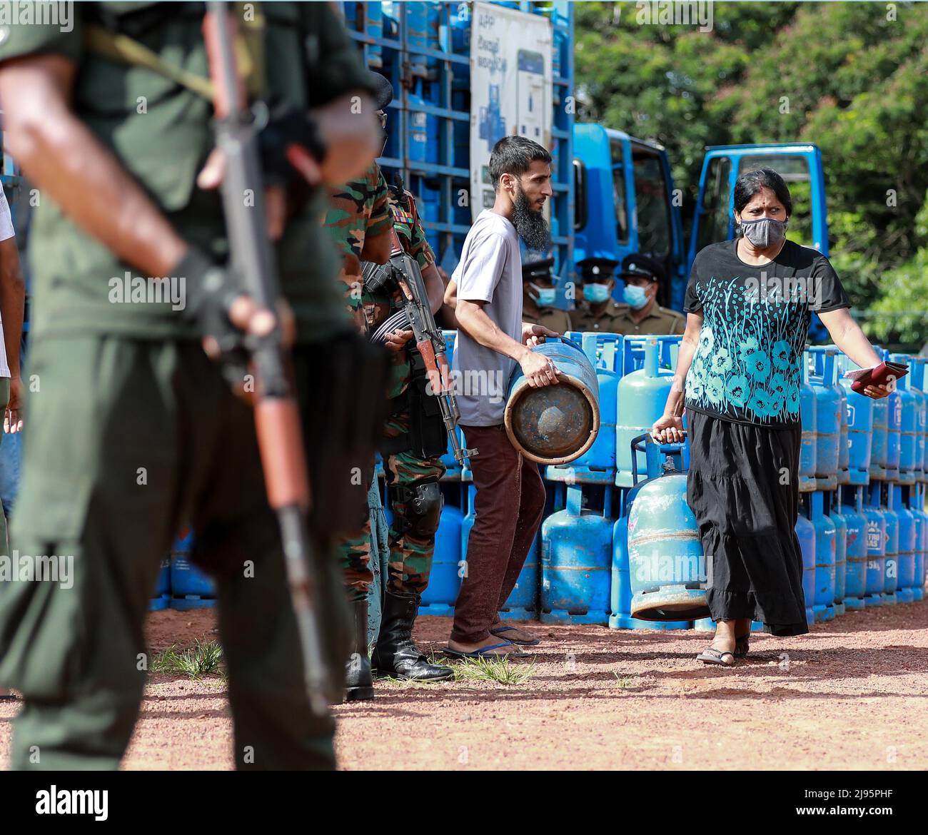 Soldiers stand guard as people queue to buy liquefied petroleum hi-res ...