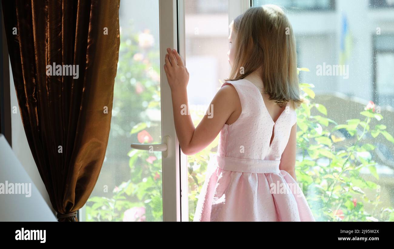 Little girl standing at open window at home back view Stock Photo - Alamy