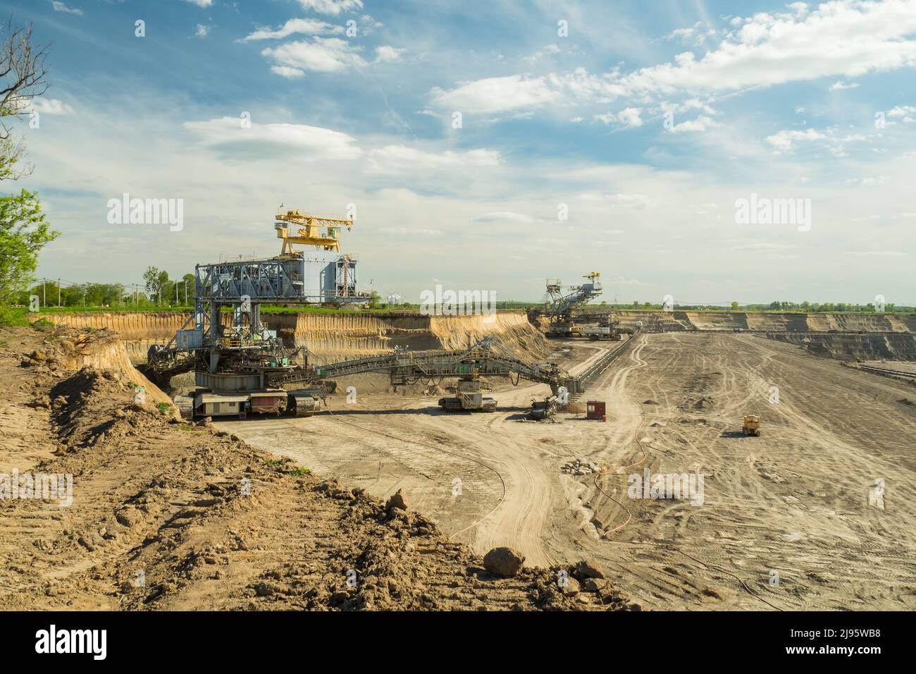 Industrial view of opencast mining quarry with machinery at work. Area ...