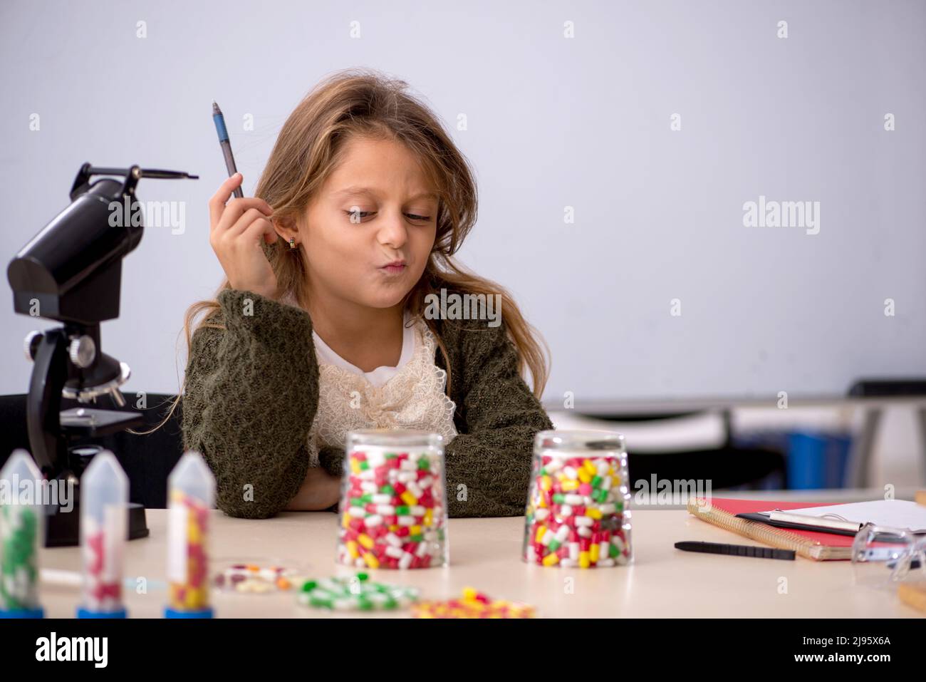 Young small girl chemist in the classroom Stock Photo - Alamy