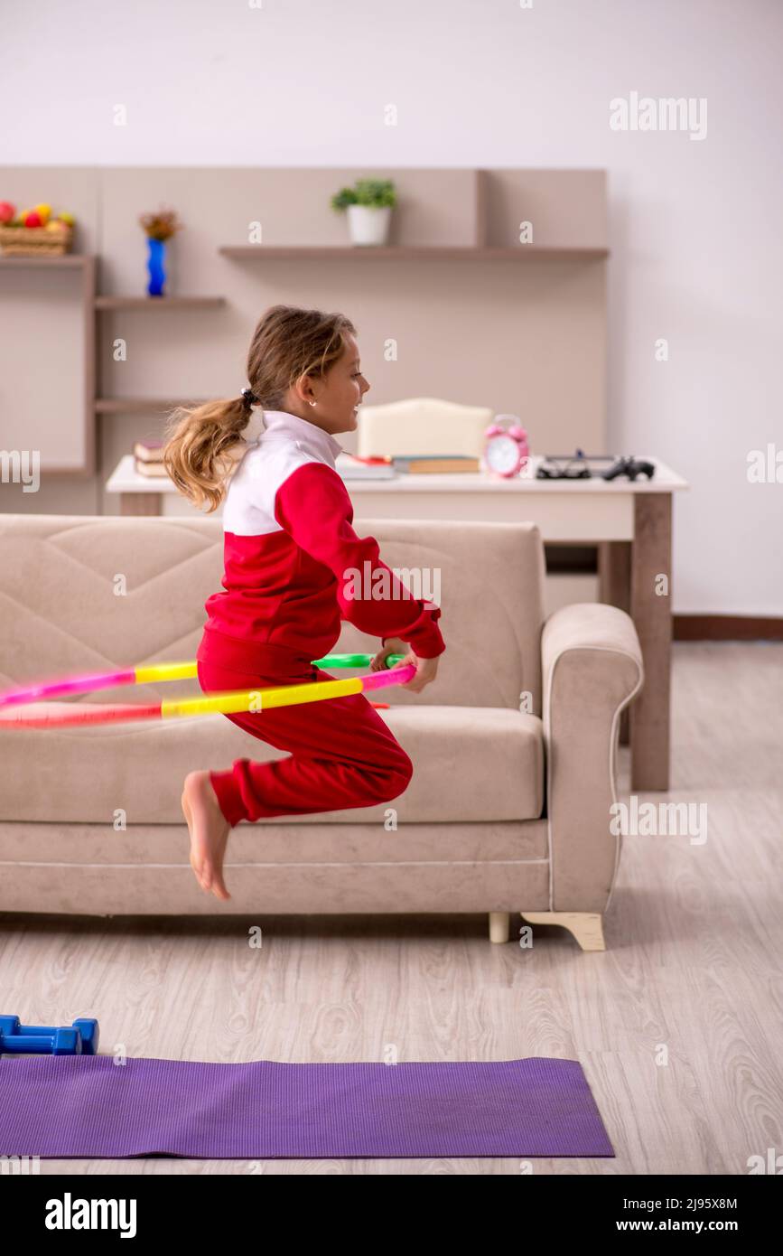 Young small girl doing sport exercises at home Stock Photo - Alamy