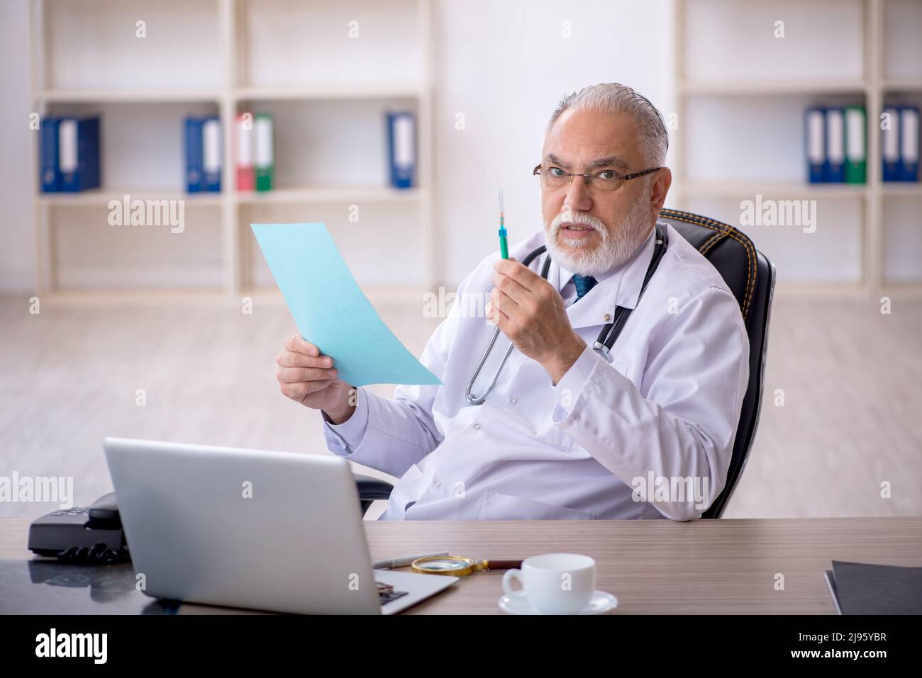 Old male doctor working at the hospital Stock Photo - Alamy