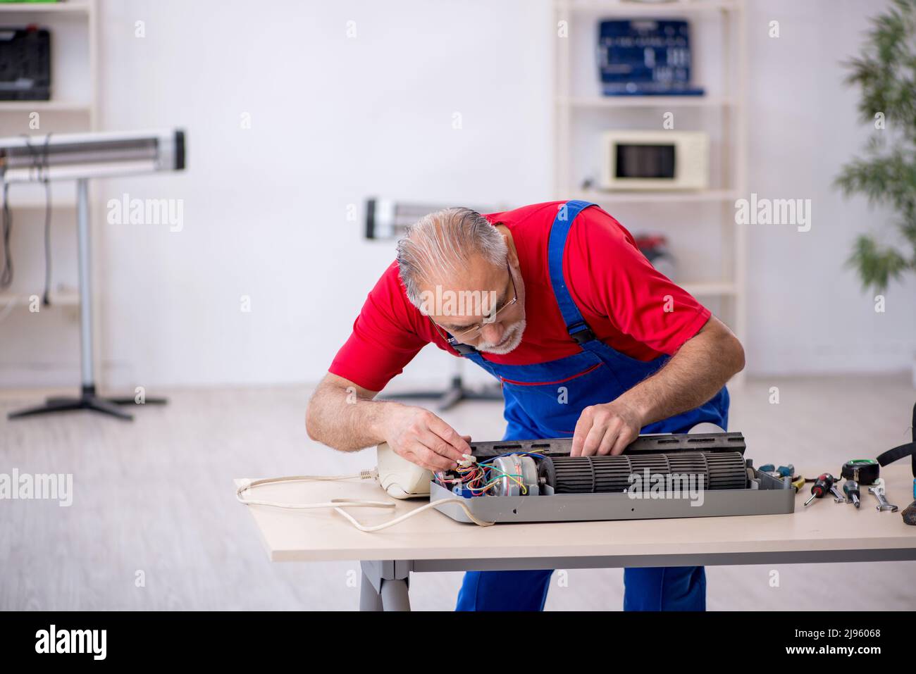 Old male repairman repairing air-conditioner Stock Photo - Alamy