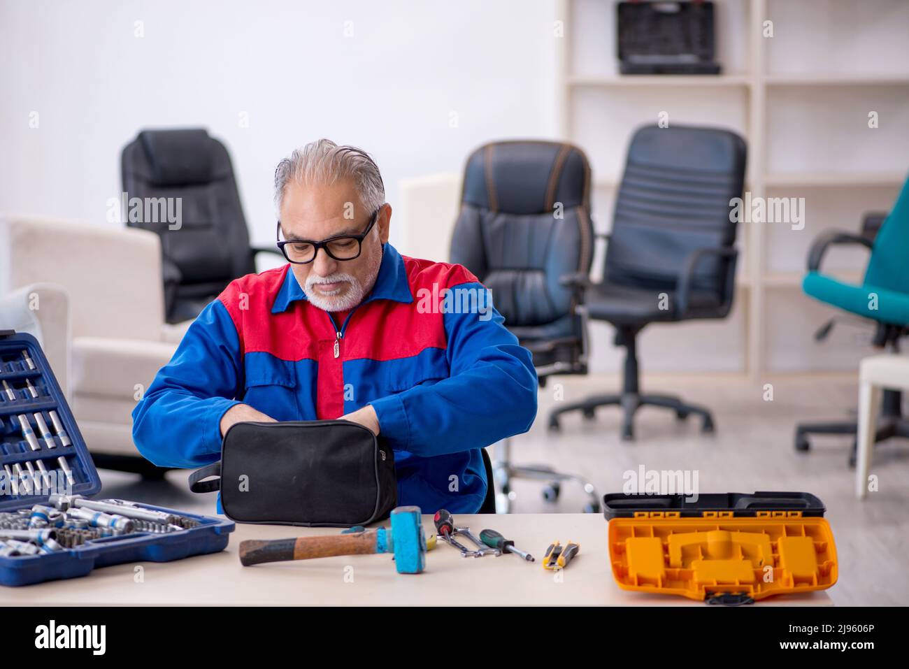 Old repairman working at workshop Stock Photo - Alamy