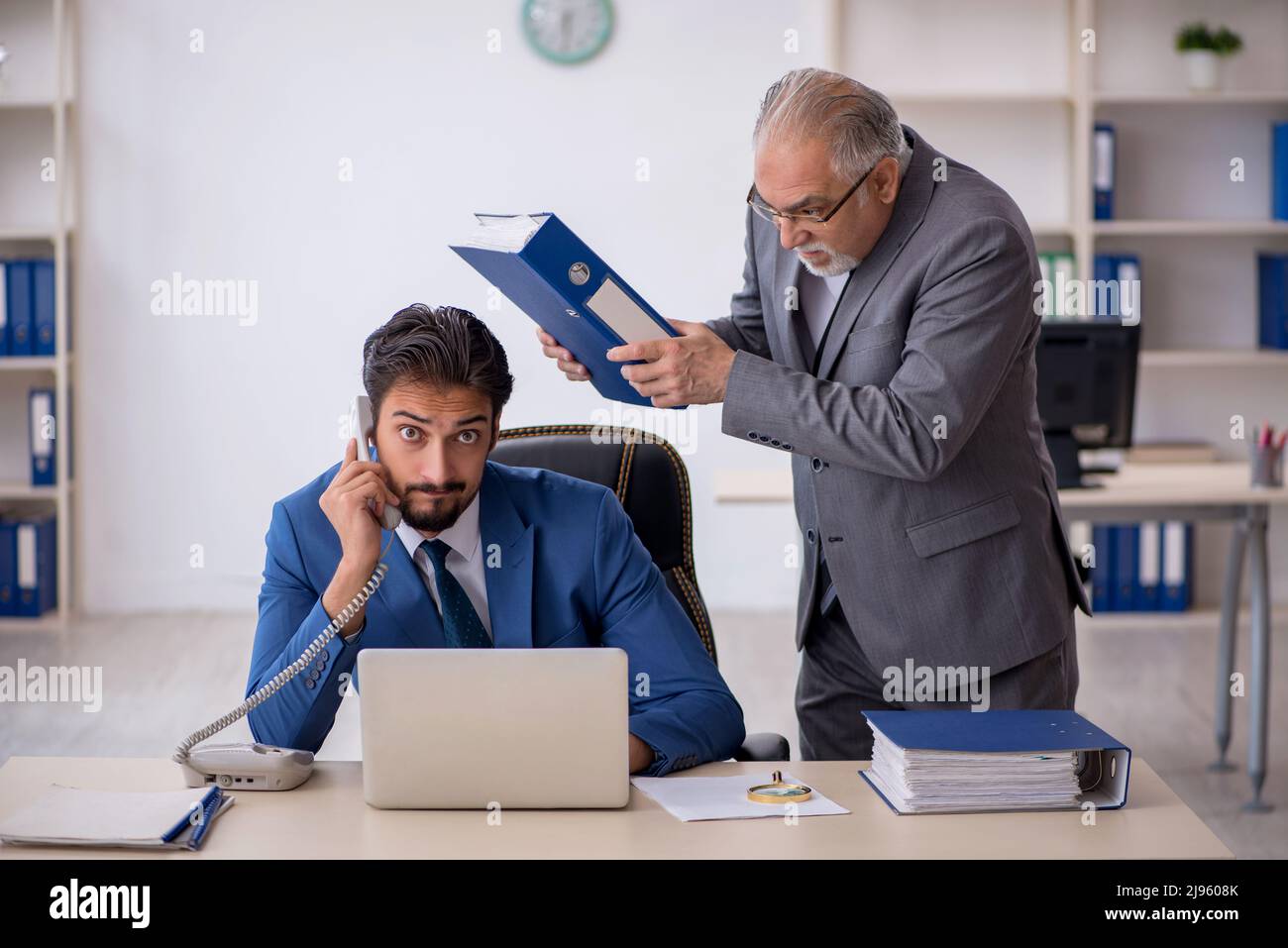 Old boss and young employee working at workplace Stock Photo - Alamy