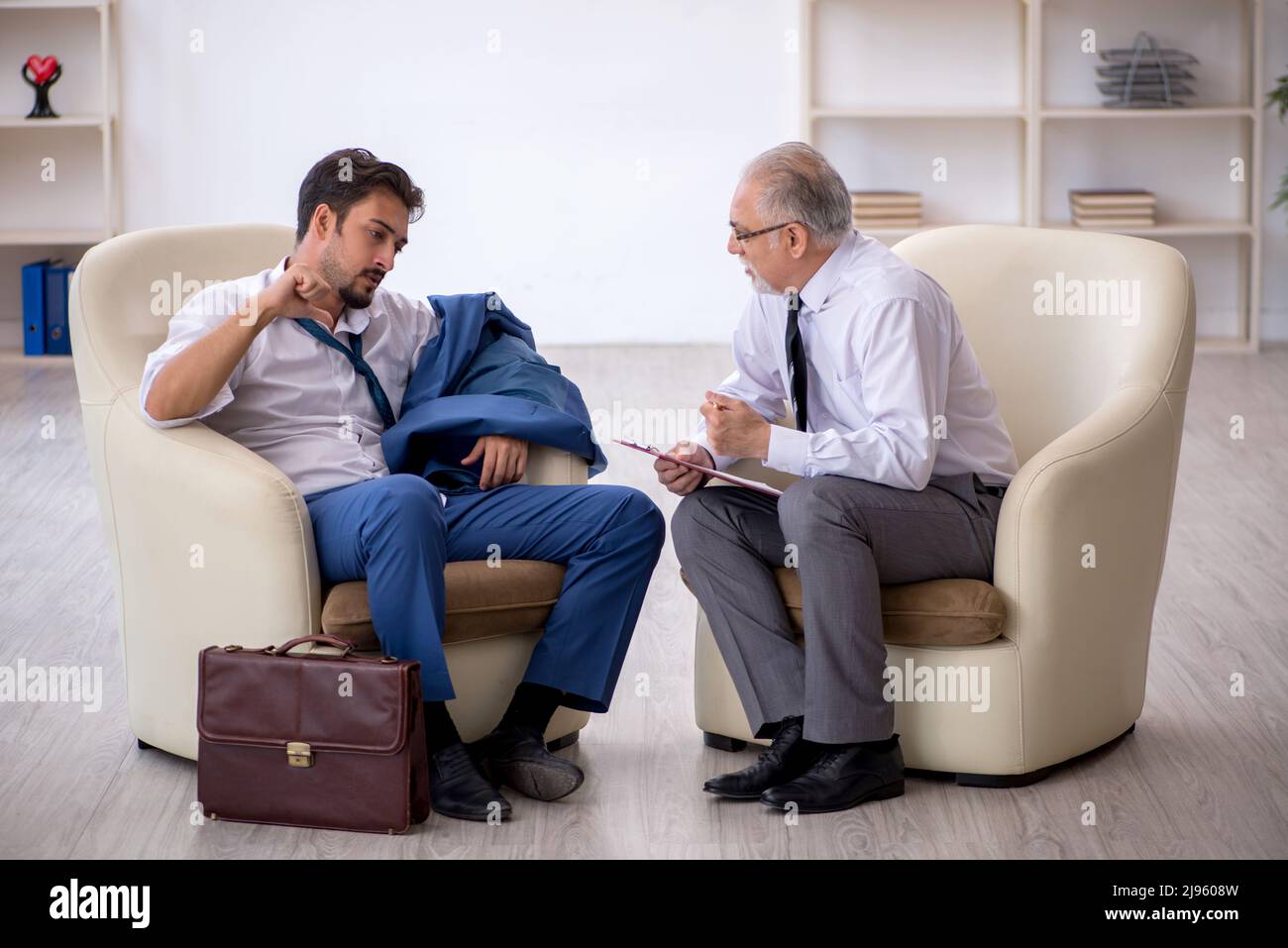 Young businessman visiting old psychologist Stock Photo - Alamy