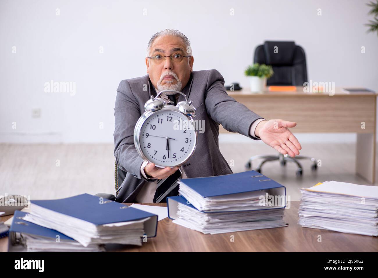 Old male boss in time management concept Stock Photo - Alamy