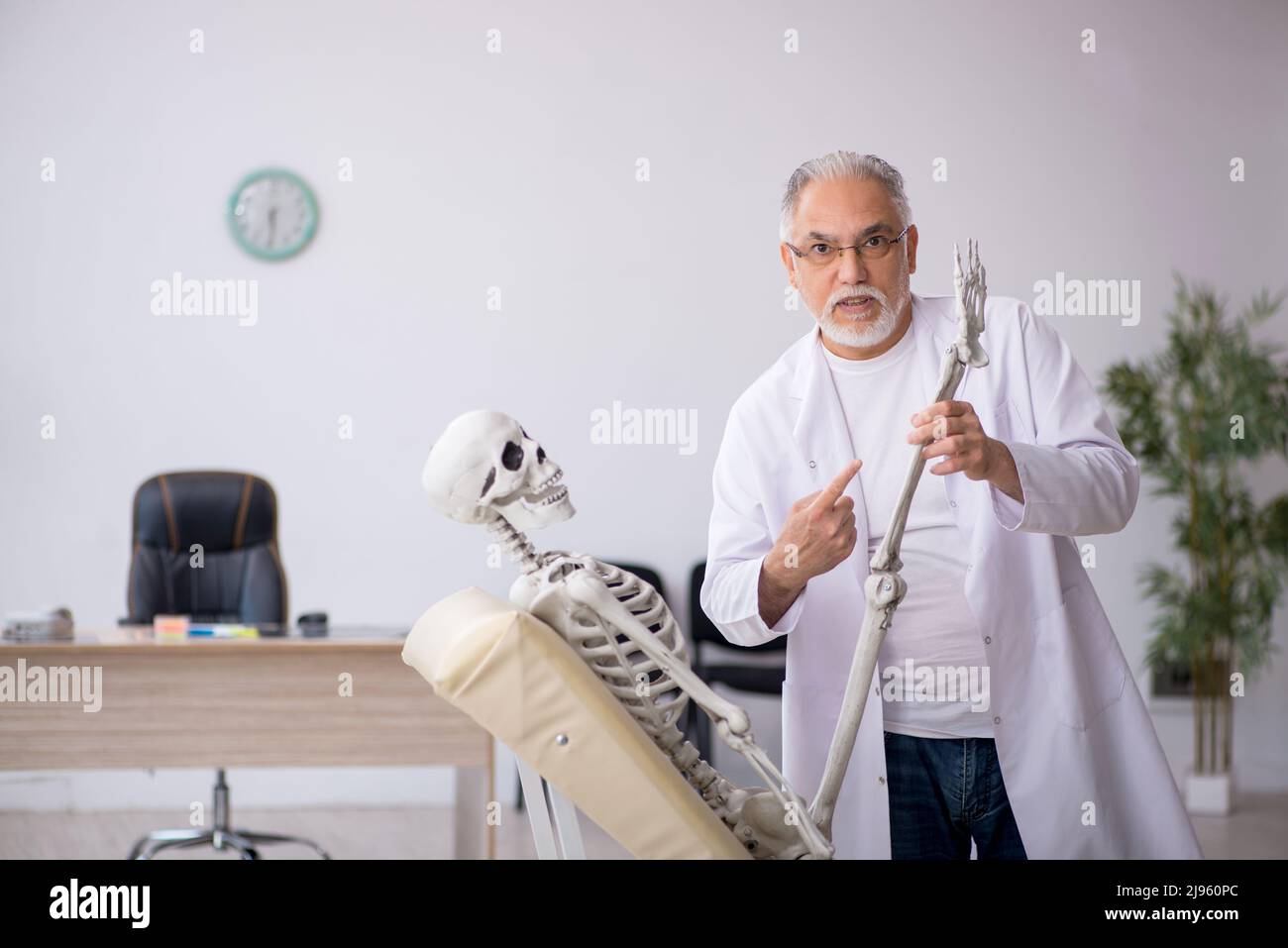 Old doctor with skeleton at the hospital Stock Photo - Alamy