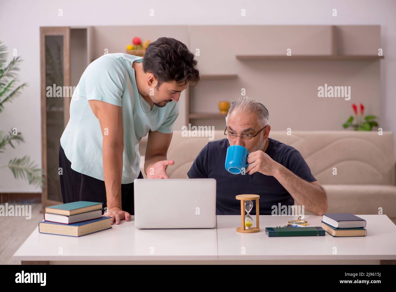 Grandfather and grandson at home with computer during pandemic Stock ...