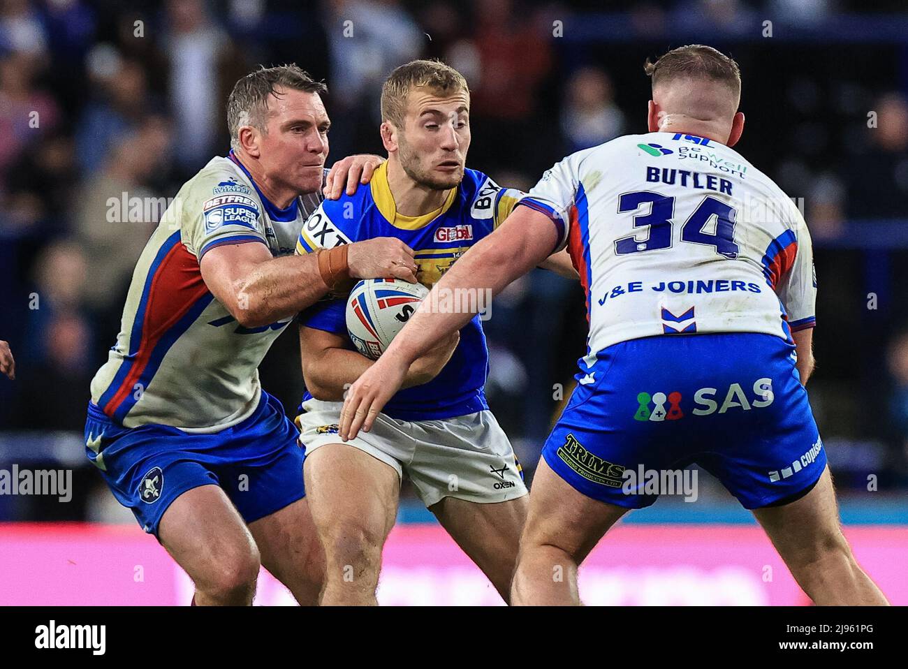 Jarrod O'Connor of Leeds Rhinos is tackled by Matty Ashurst #11 of ...