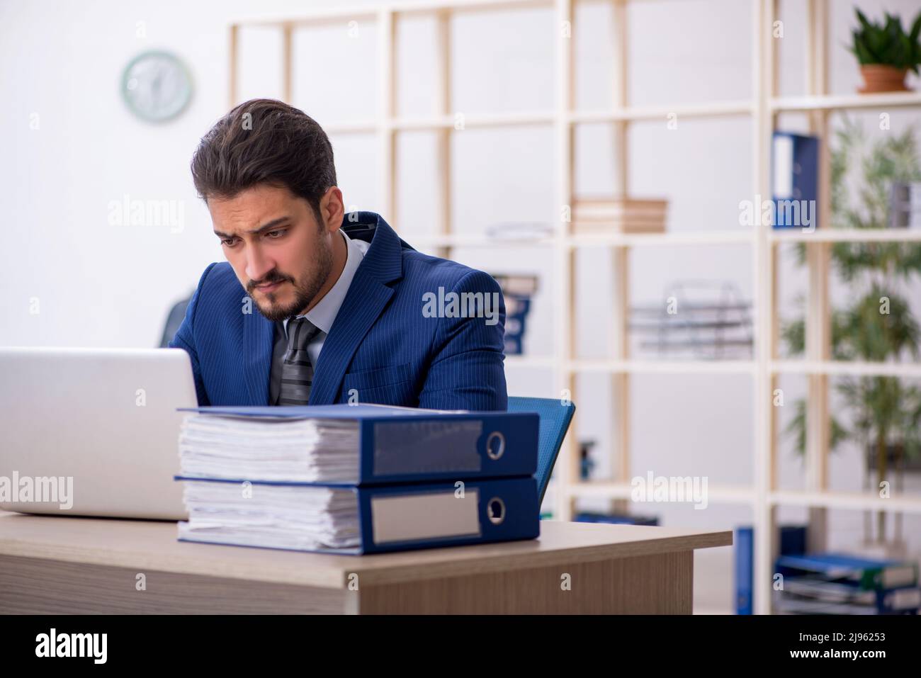 Young male employee working in the office Stock Photo - Alamy