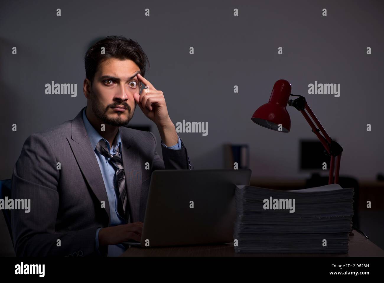 Young employee working late in the office Stock Photo - Alamy