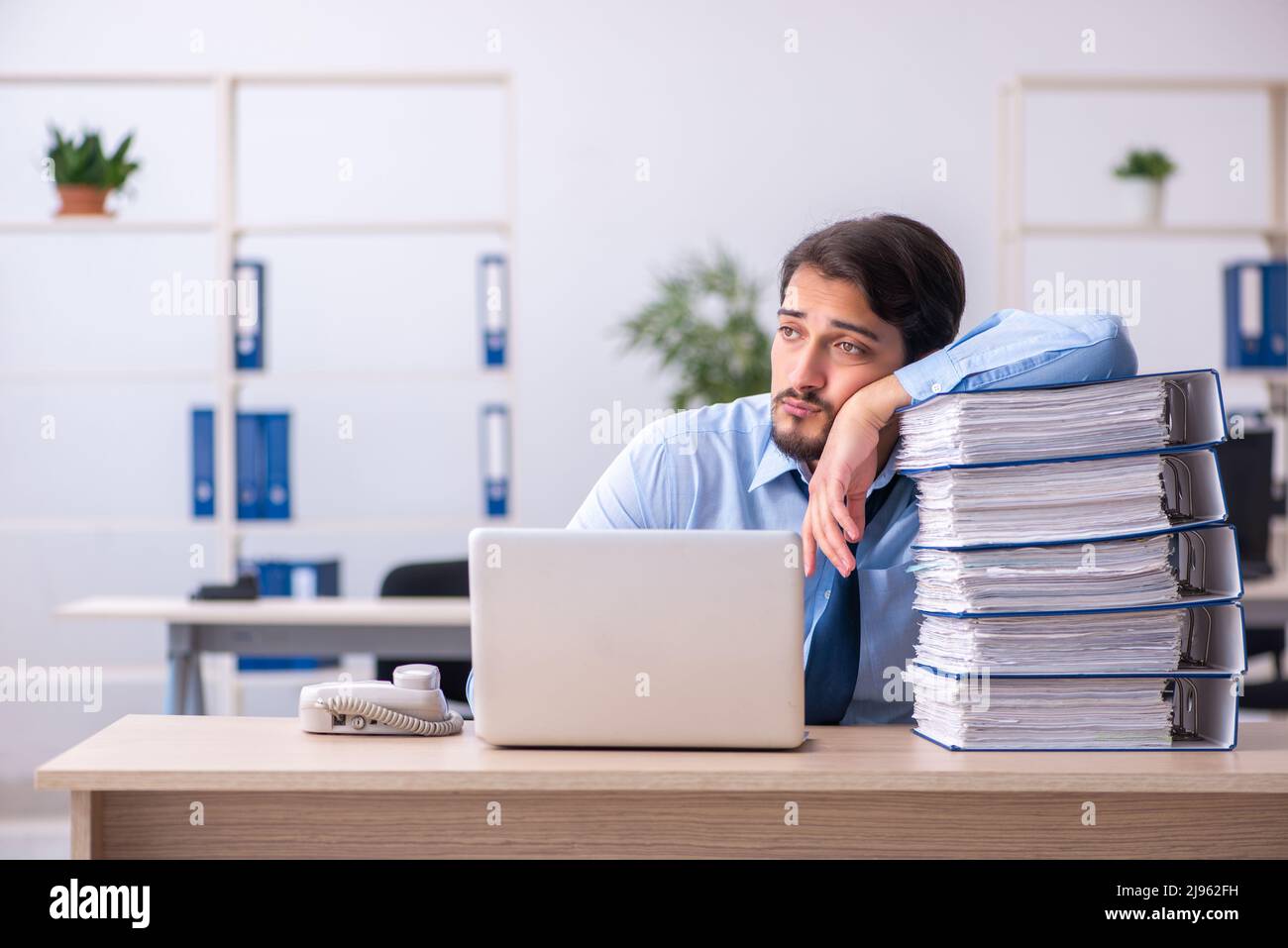 Young businessman employee and too much work in the office Stock Photo ...