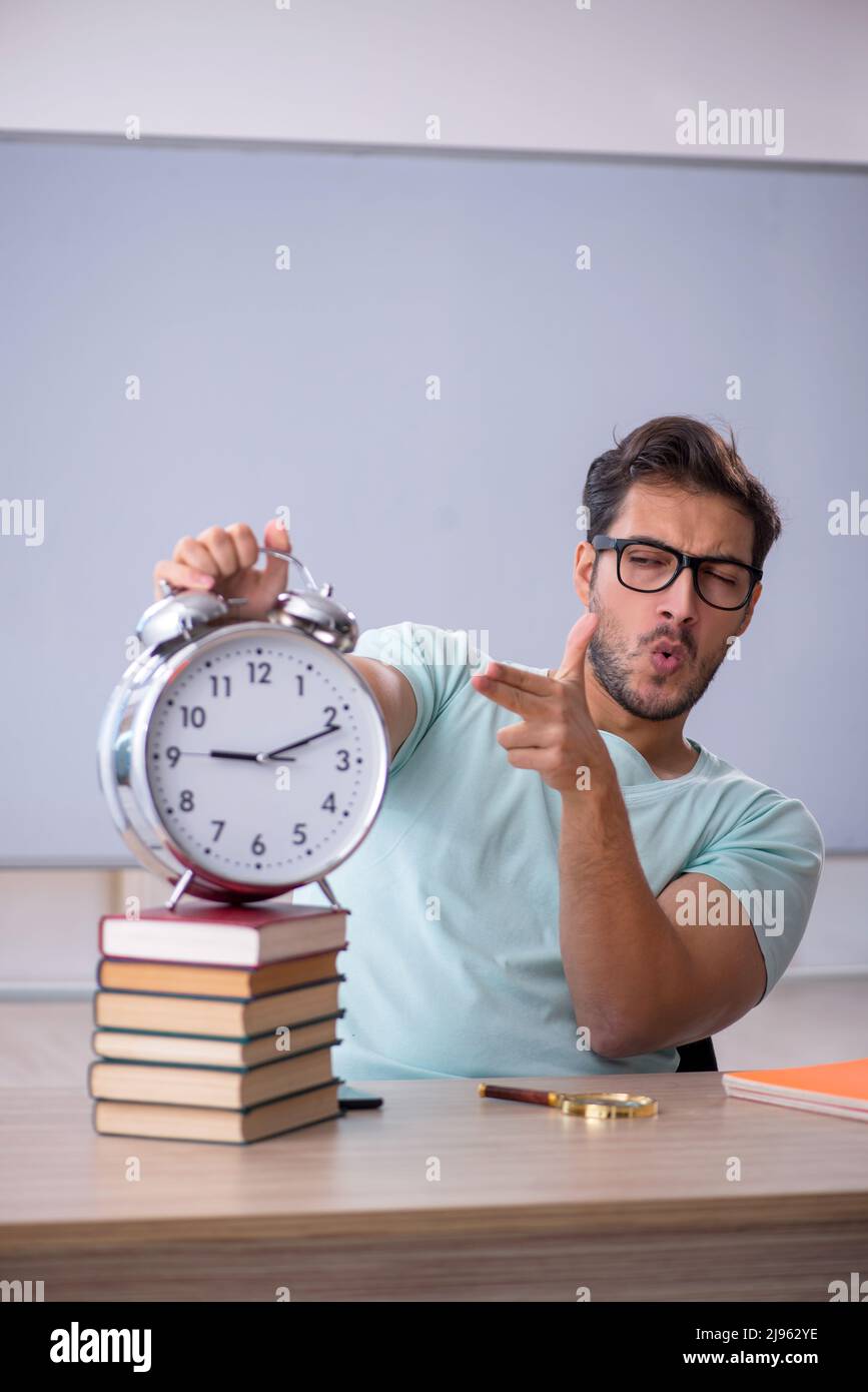 Young student in time management concept in the classroom Stock Photo ...