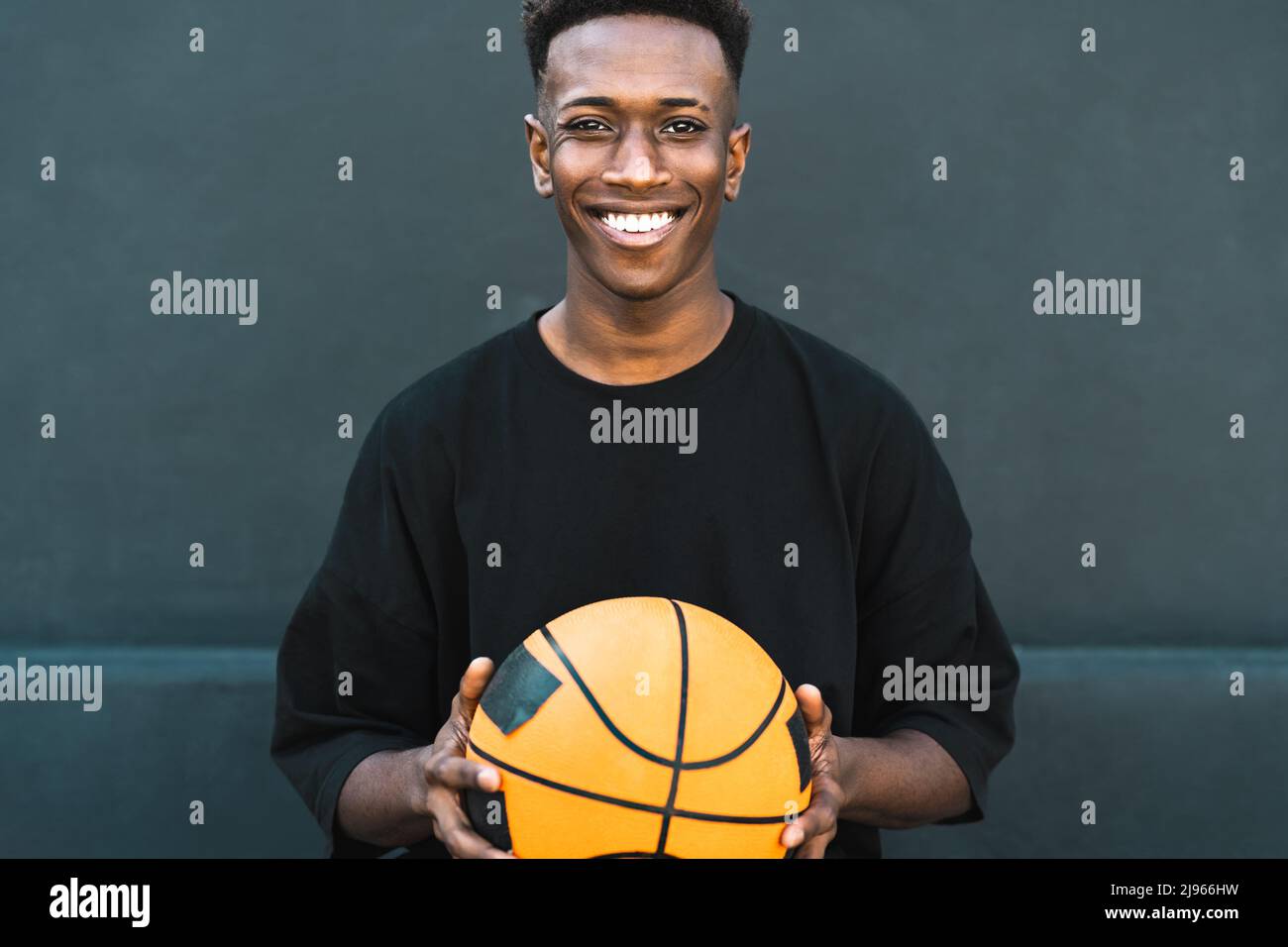Happy young African man playing basketball outdoor - Urban sport ...