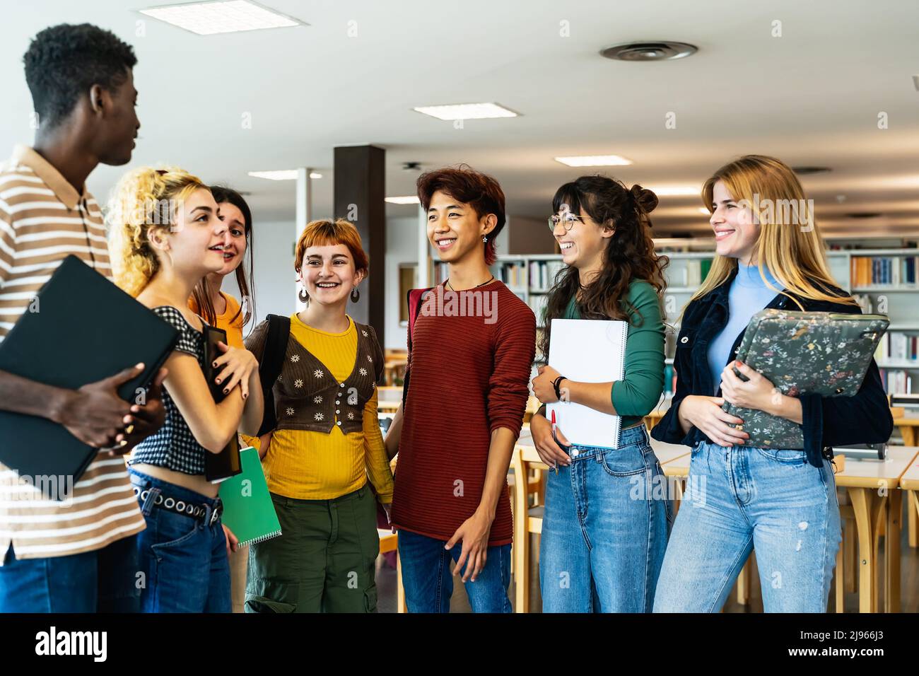Young university students standing inside library - School education ...
