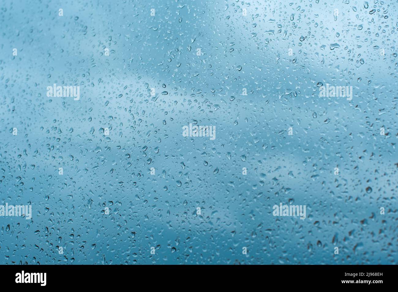 Drops of rain on the window glass. Shallow DOF. Window after rain. Blue ...