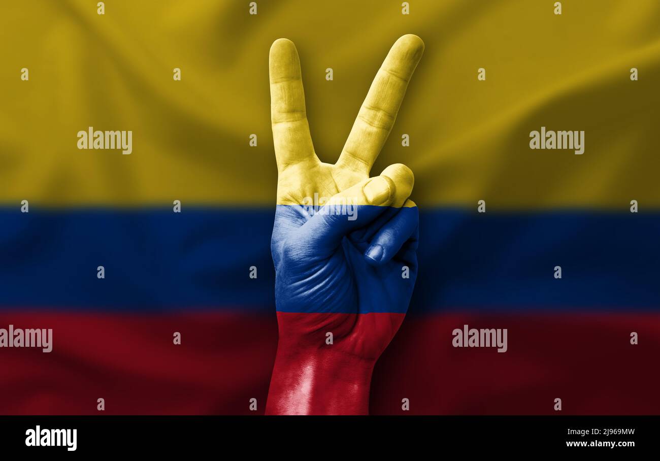 Hand making the V victory sign with flag of colombia Stock Photo - Alamy