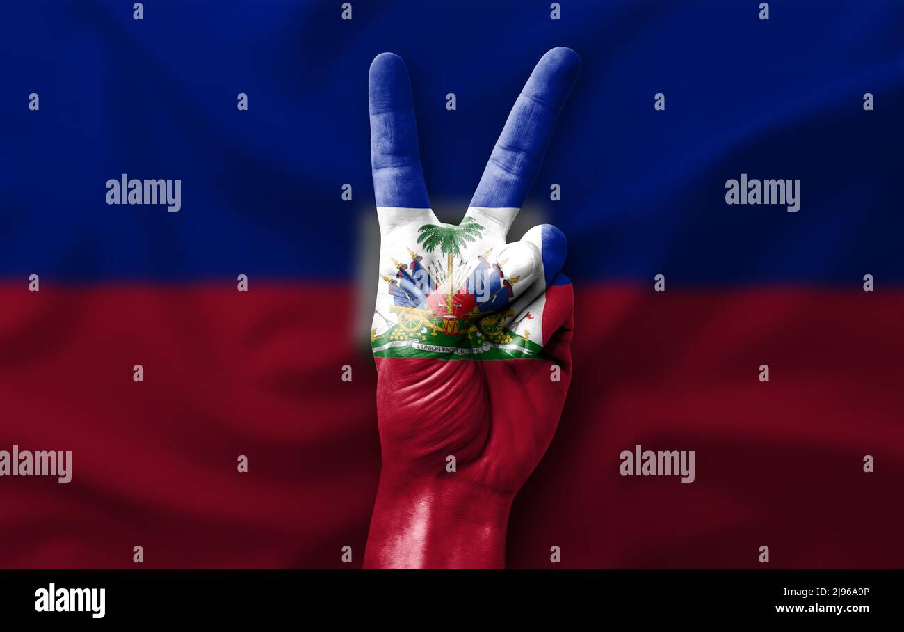 Hand making the V victory sign with flag of haiti Stock Photo - Alamy