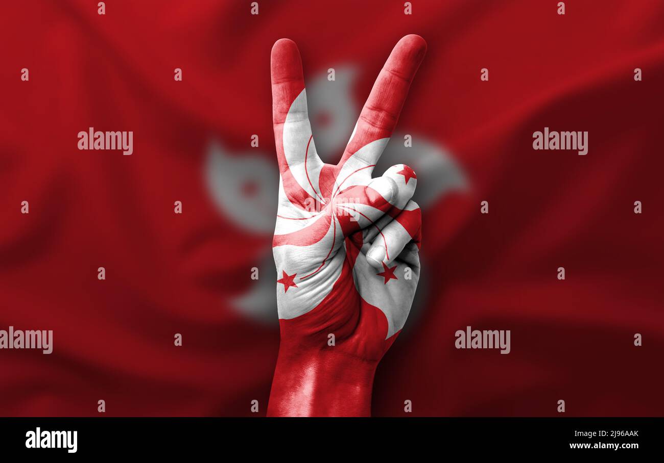 Hand making the V victory sign with flag of hong kong Stock Photo - Alamy