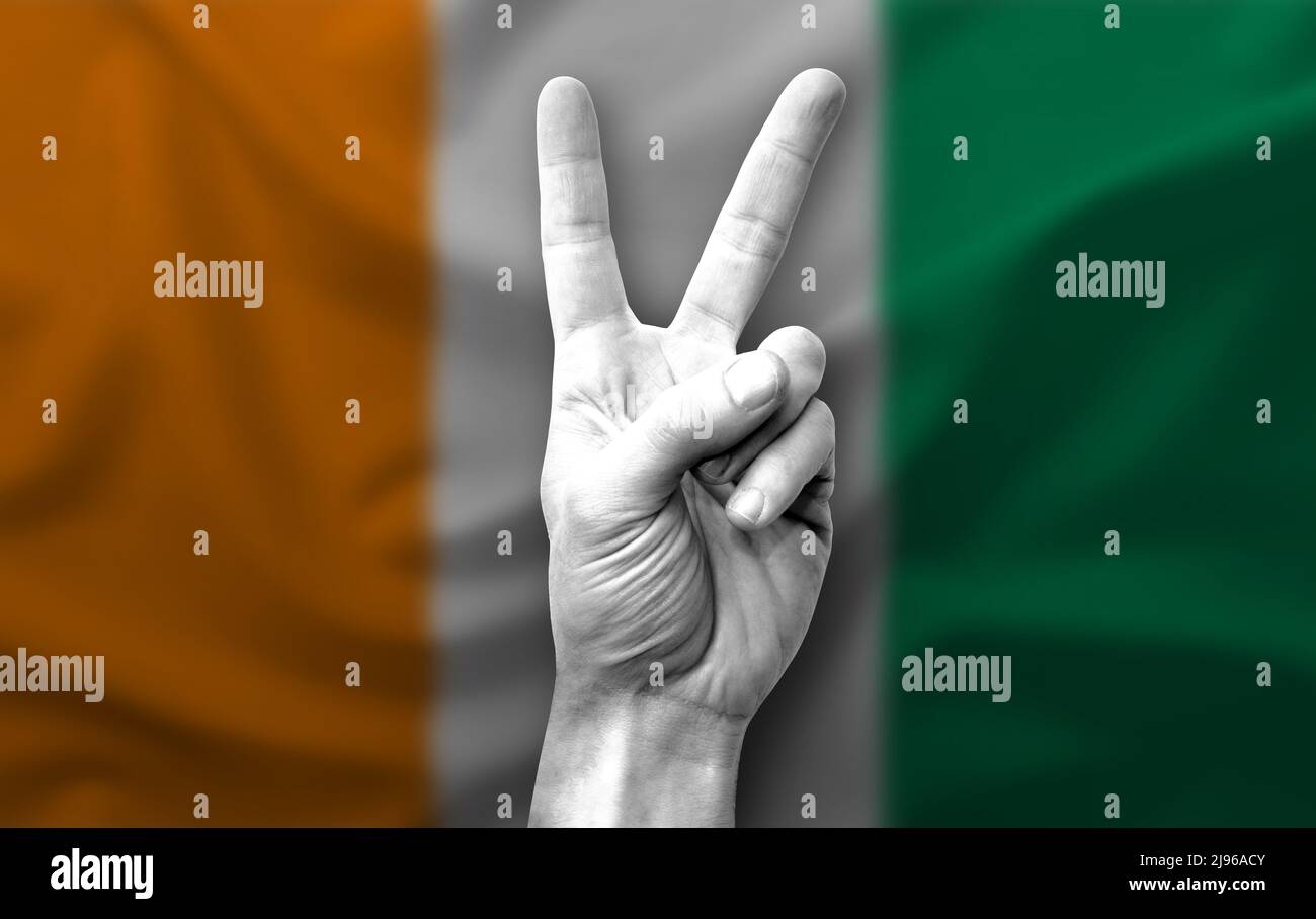 Hand making the V victory sign with flag of ivory coast Stock Photo - Alamy