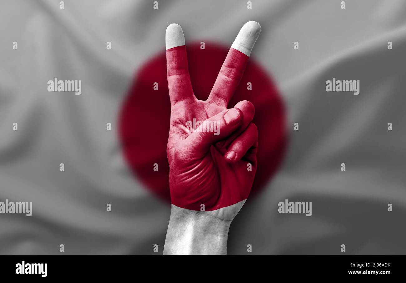 Hand making the V victory sign with flag of japan Stock Photo - Alamy