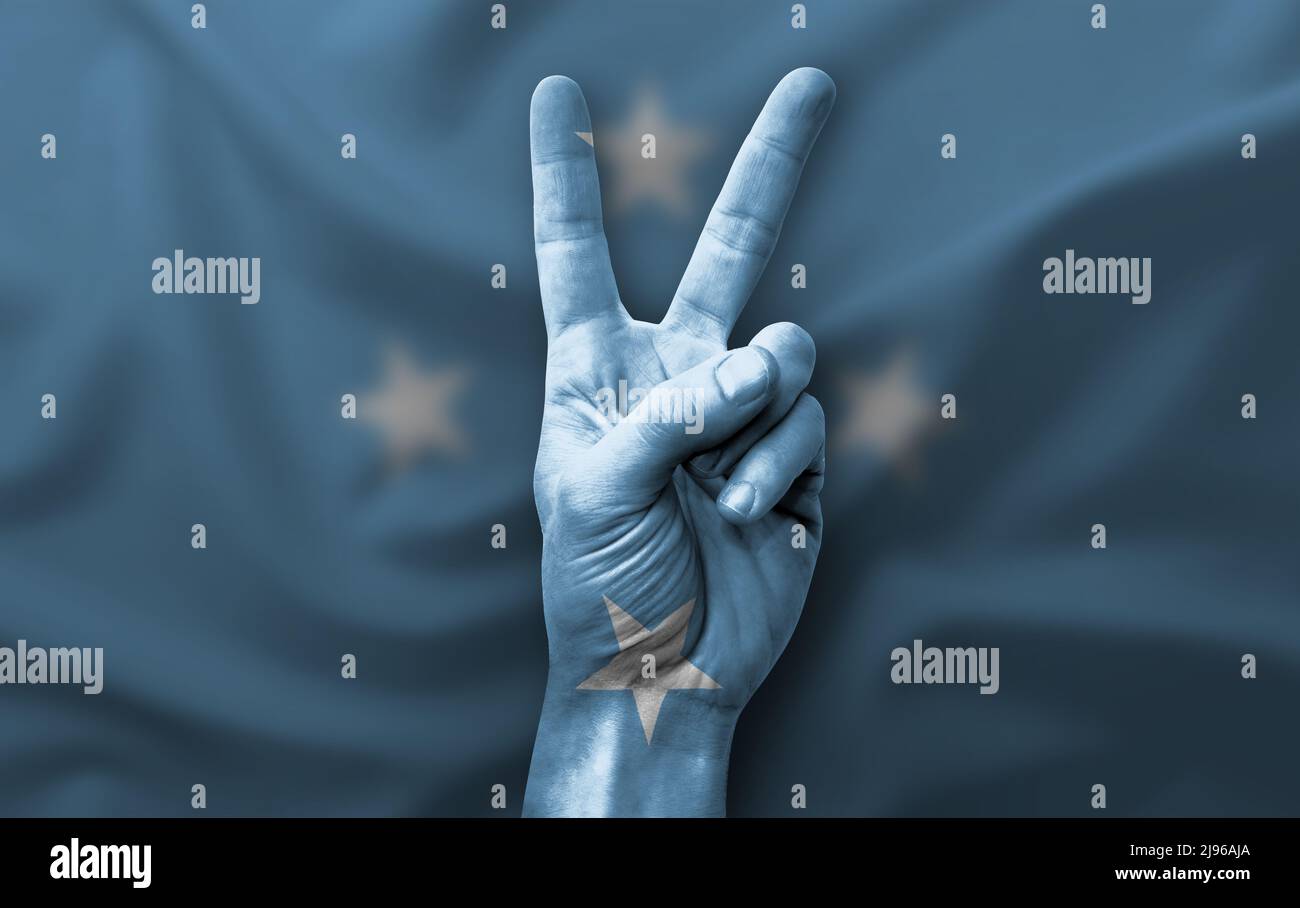 Hand making the V victory sign with flag of micronesia Stock Photo - Alamy