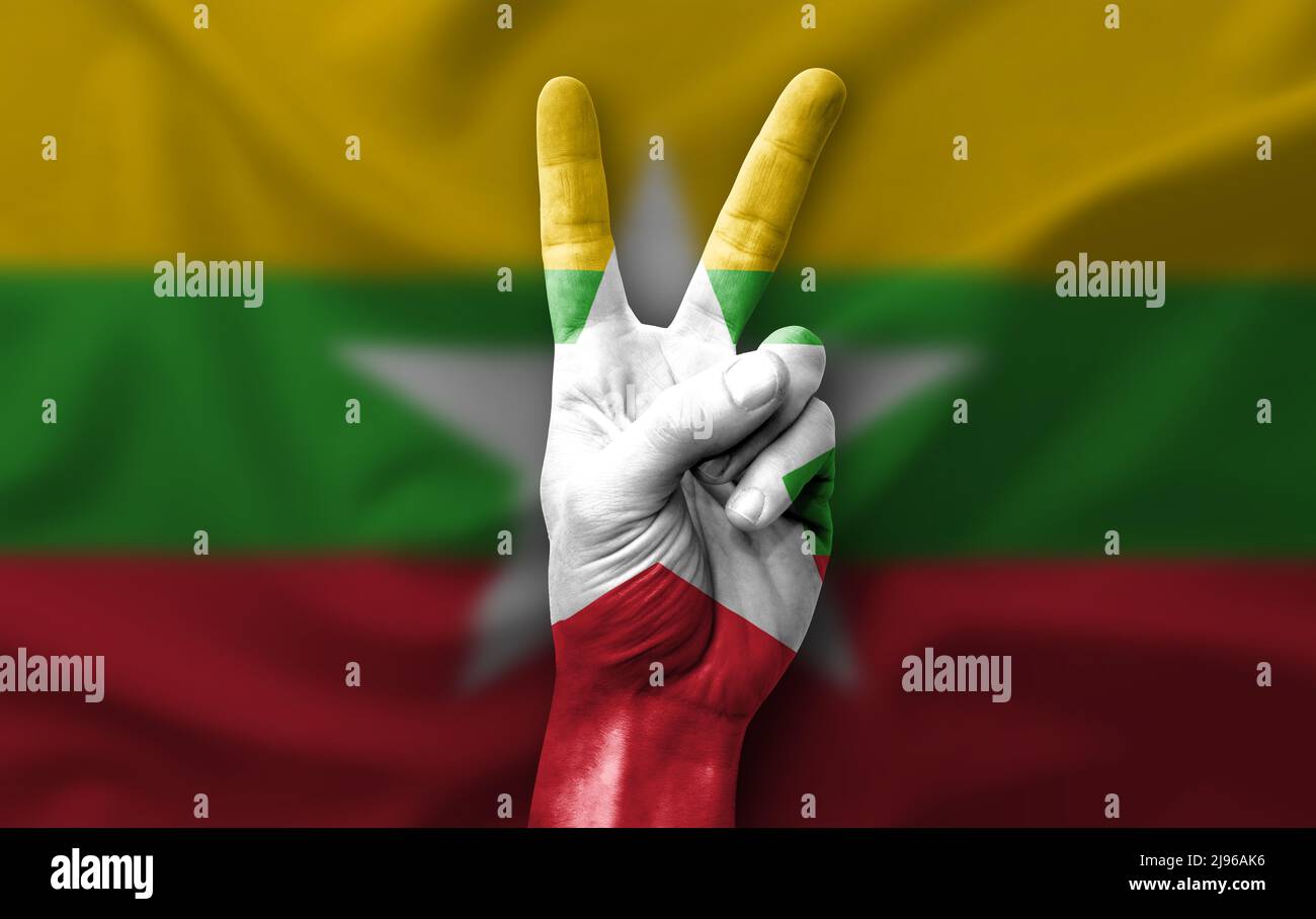 Hand making the V victory sign with flag of myanmar Stock Photo - Alamy