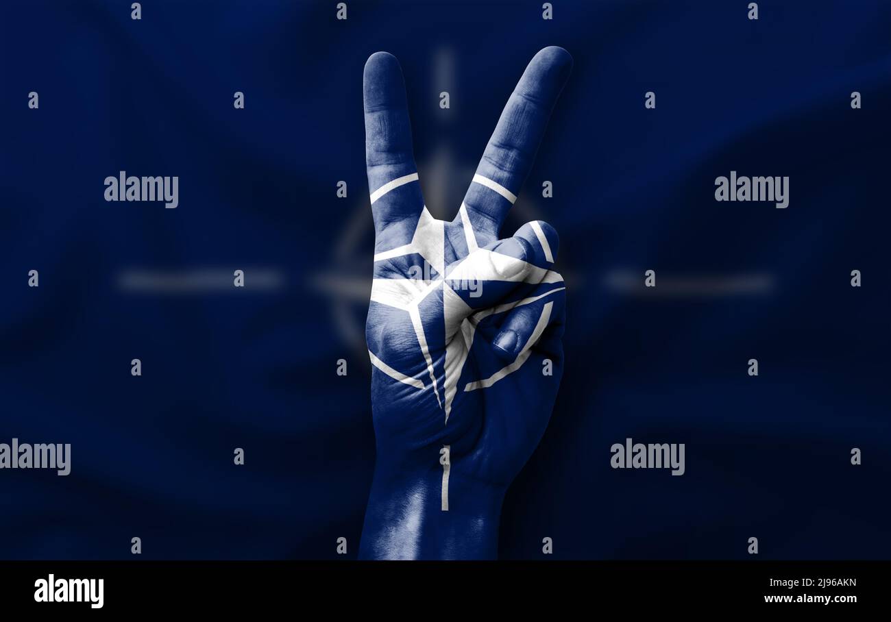 Hand making the V victory sign with flag of nato Stock Photo - Alamy