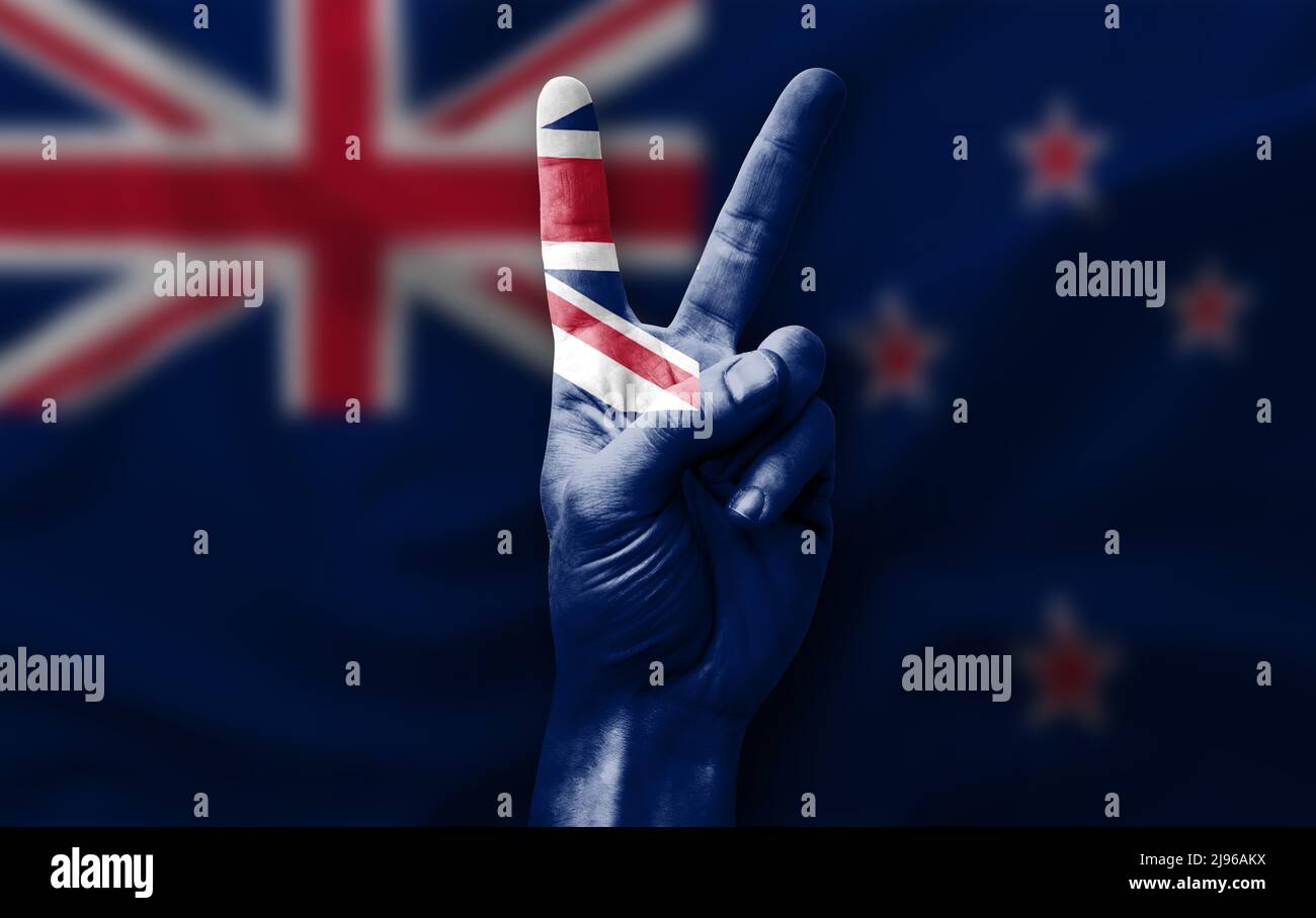 Hand making the V victory sign with flag of new zealand Stock Photo - Alamy