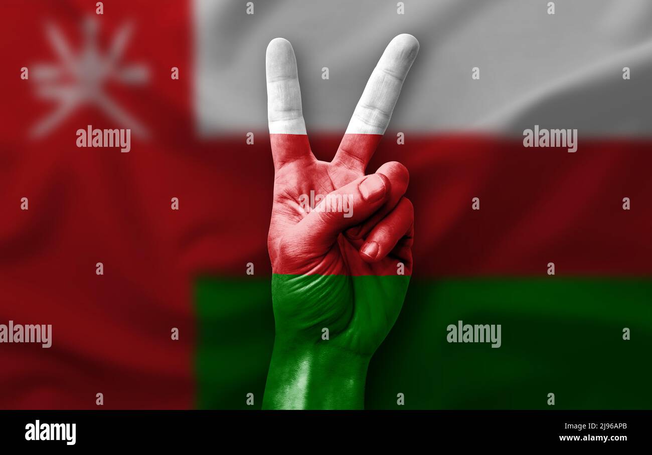 Hand making the V victory sign with flag of oman Stock Photo - Alamy