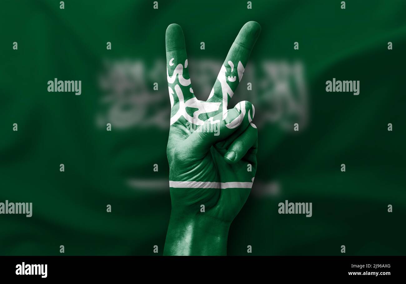 Hand making the V victory sign with flag of saudi arabia Stock Photo ...