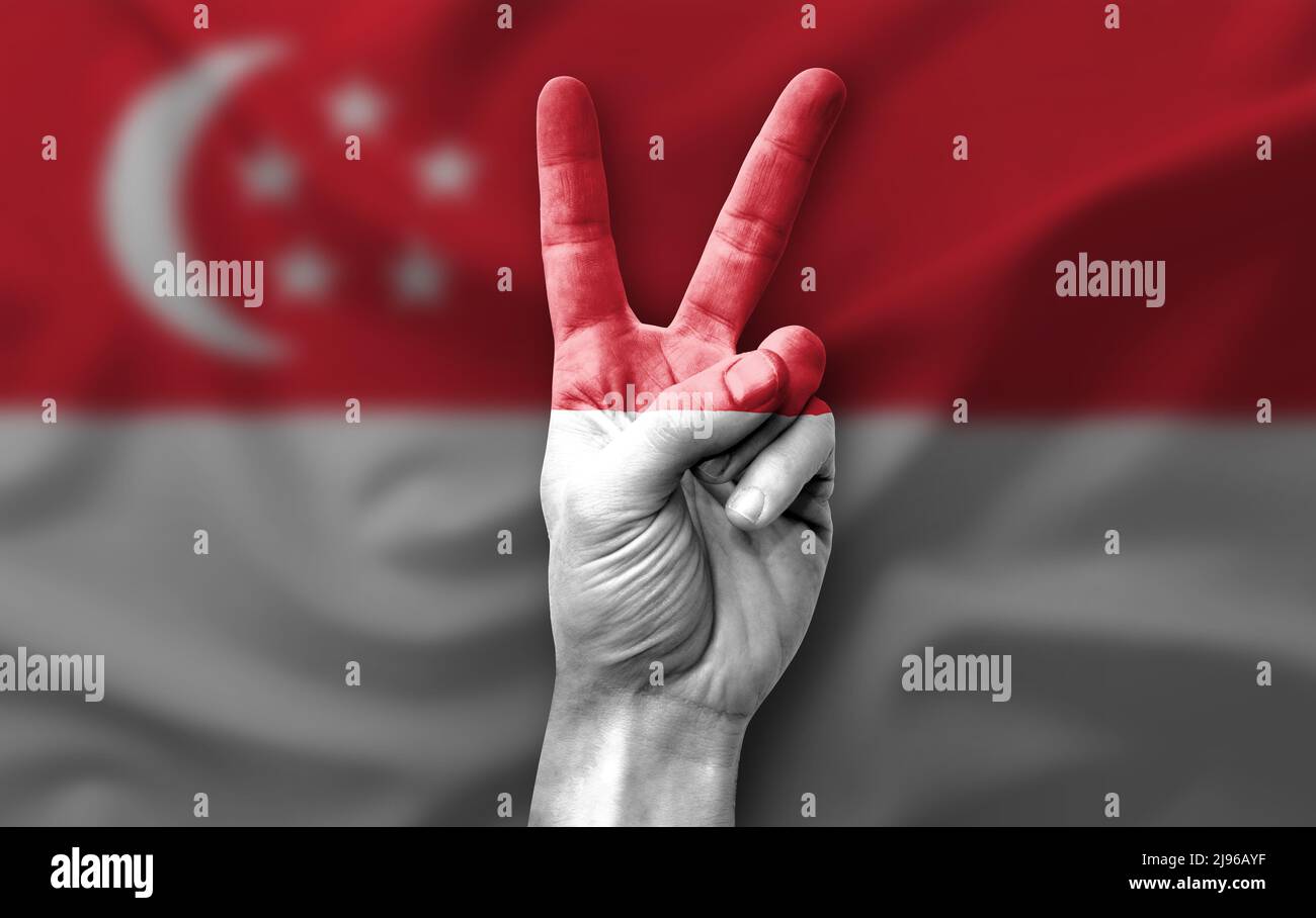 Hand making the V victory sign with flag of singapore Stock Photo - Alamy