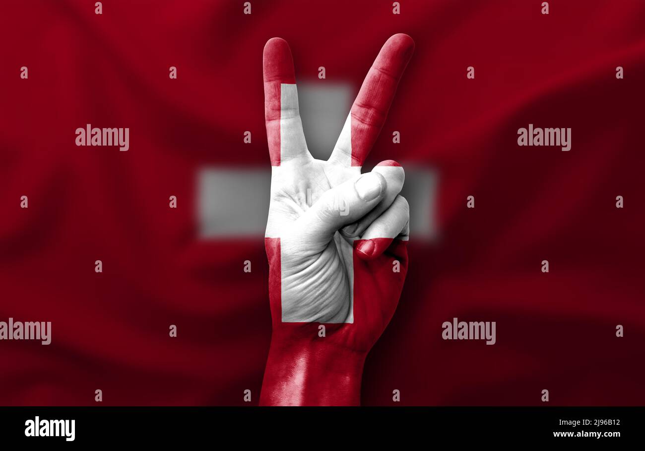 Hand making the V victory sign with flag of switzerland Stock Photo - Alamy