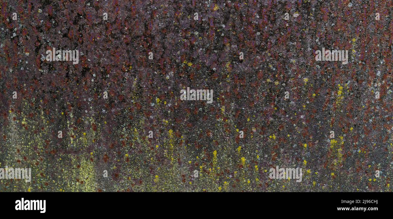 Painted iron surface with a large rusty, black spot and metal corrosion ...