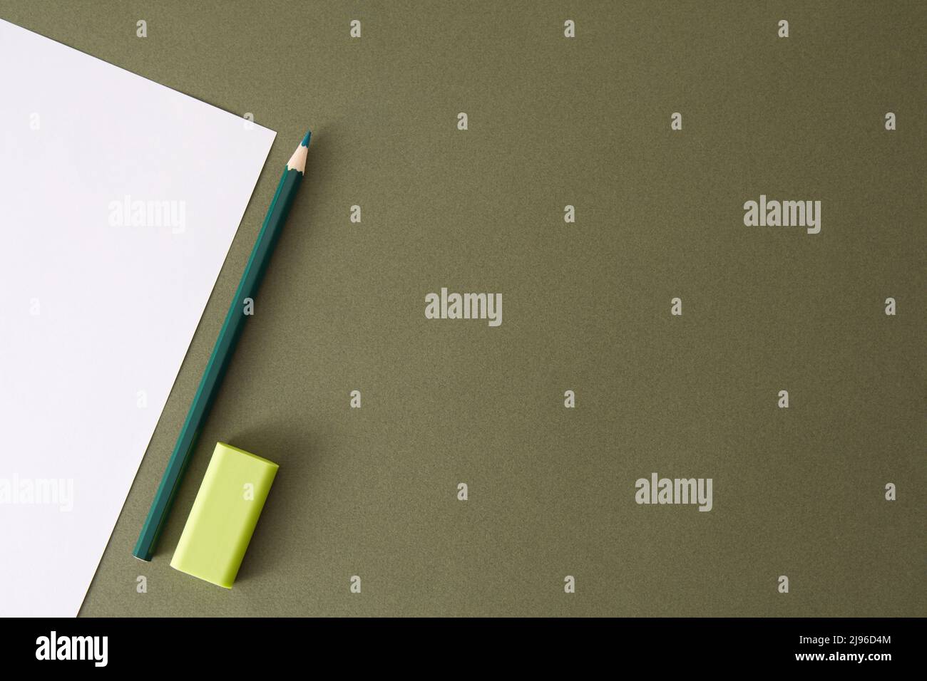 Green pencil, white paper and eraser. Empty place for text or drawing ...
