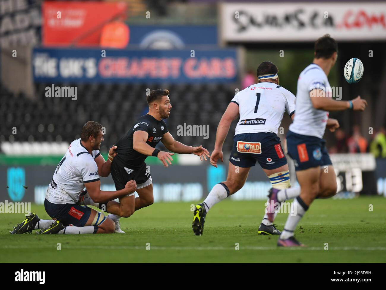 Rhys Webb of Ospreys Rugby, gets the ball away under pressure from Walt ...