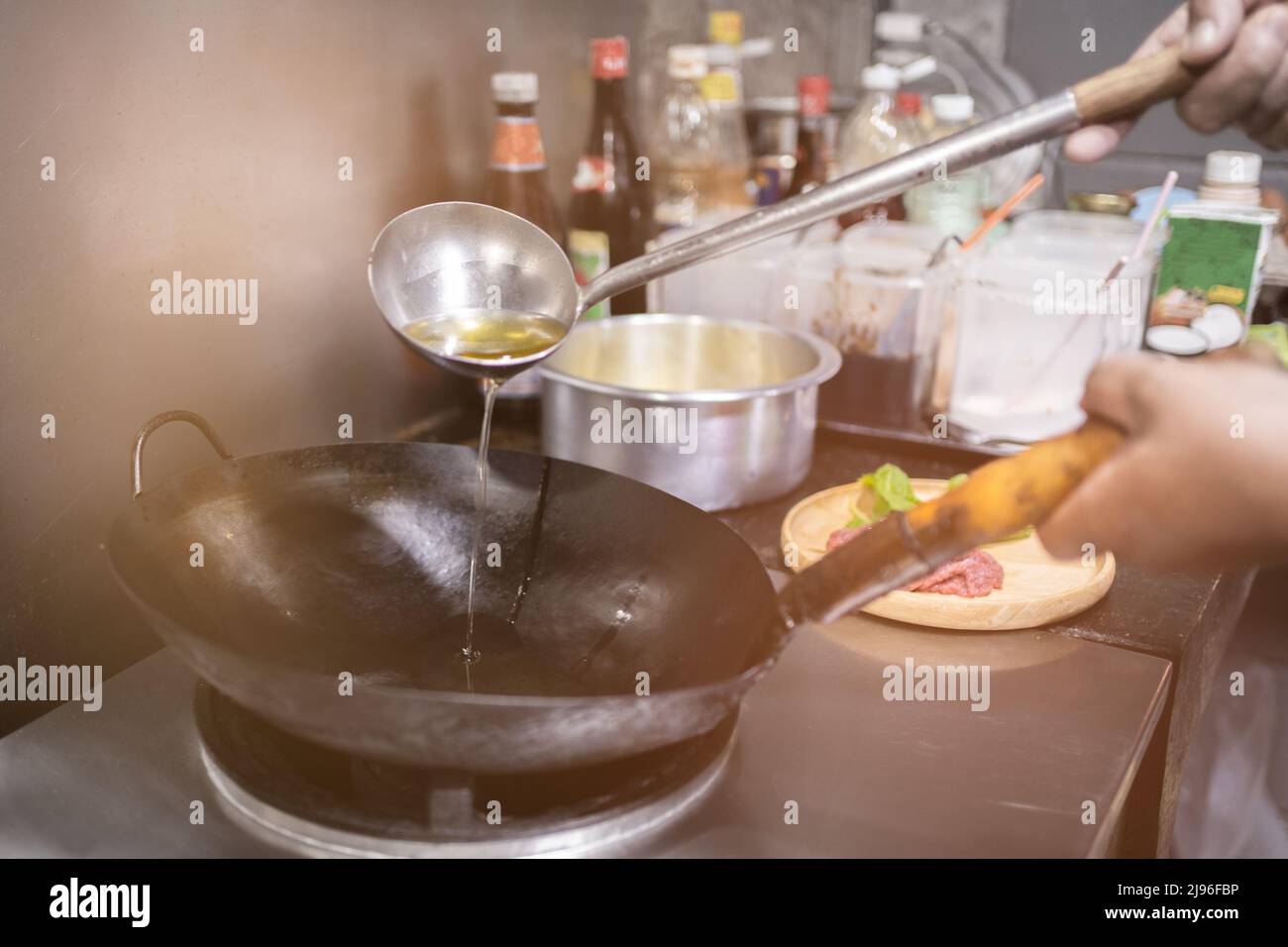 Chef stir fry in wok. Dramatic cooking with fire hard Stock Photo - Alamy