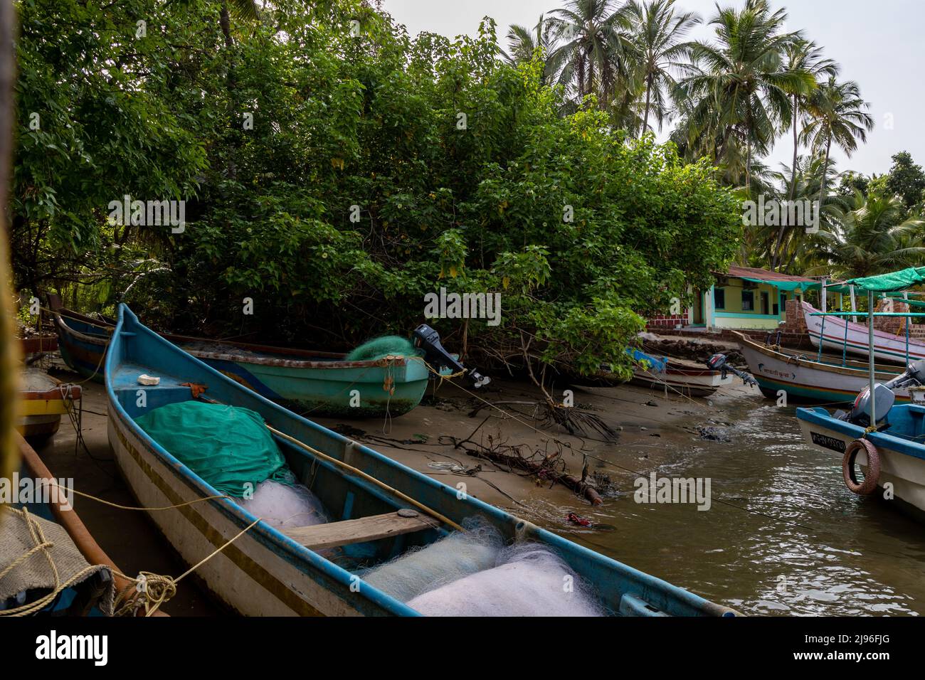 Fishing boats kept on the shore of Karli River with fishing nets in it ...