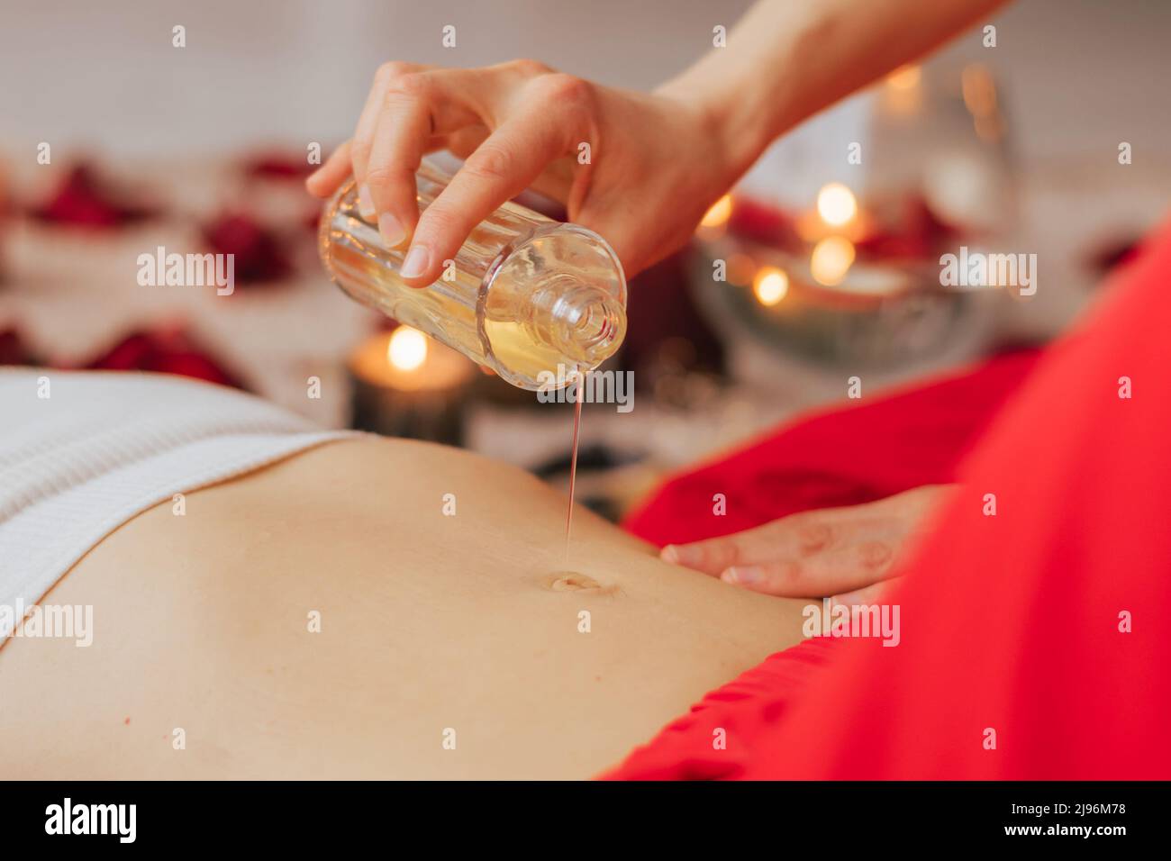 Woman master of reiki pours oil for massage on the female body, concept ...