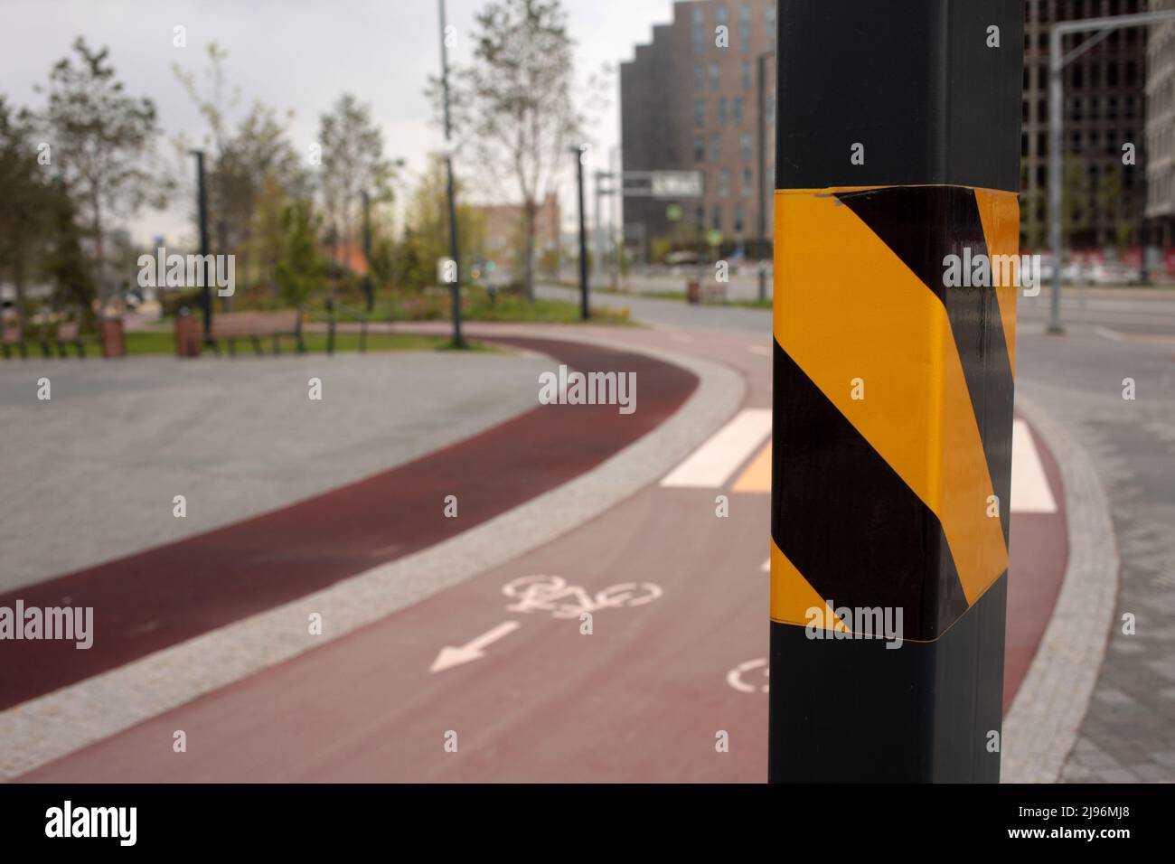 Striped markings on pole that limits bike path in park. selective focus ...