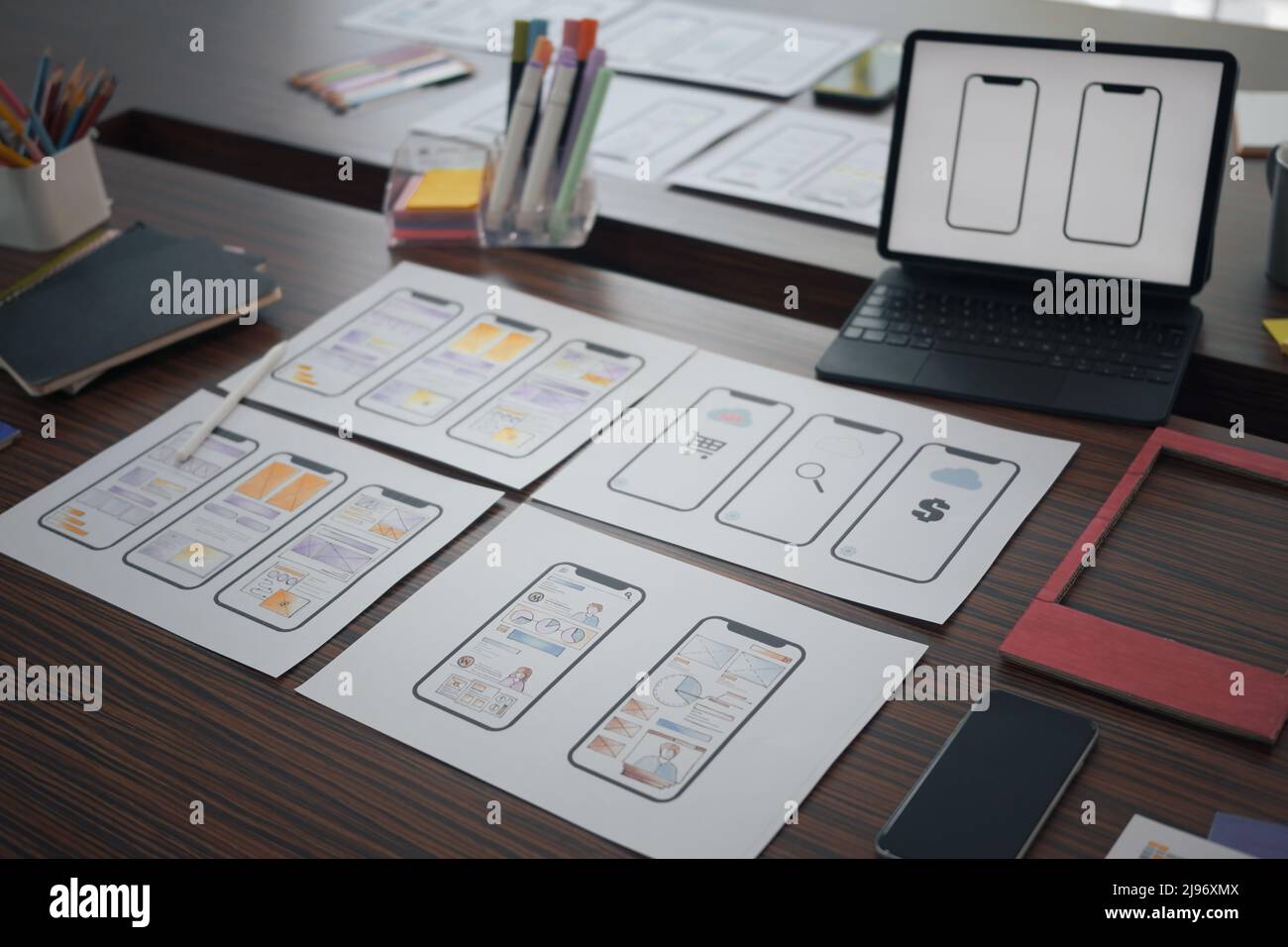 Digital tablet and wireframe sketches for mobile application on wooden ...