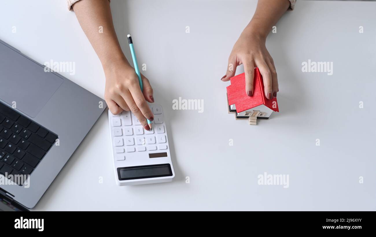 Overhead view real estate agent using calculator on white office desk ...