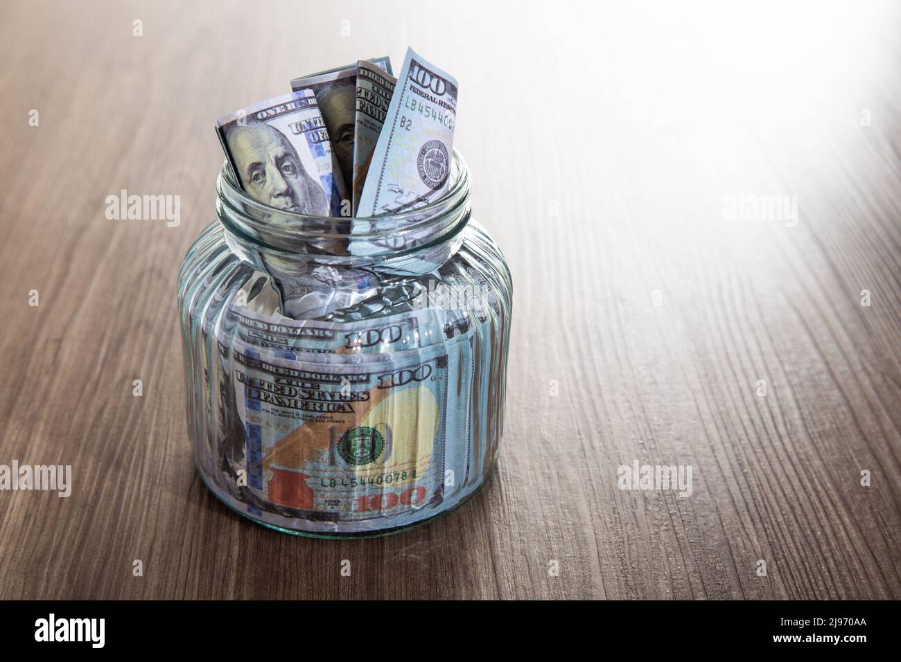 Glass jar with many of dollars money, Saving Concept Stock Photo - Alamy