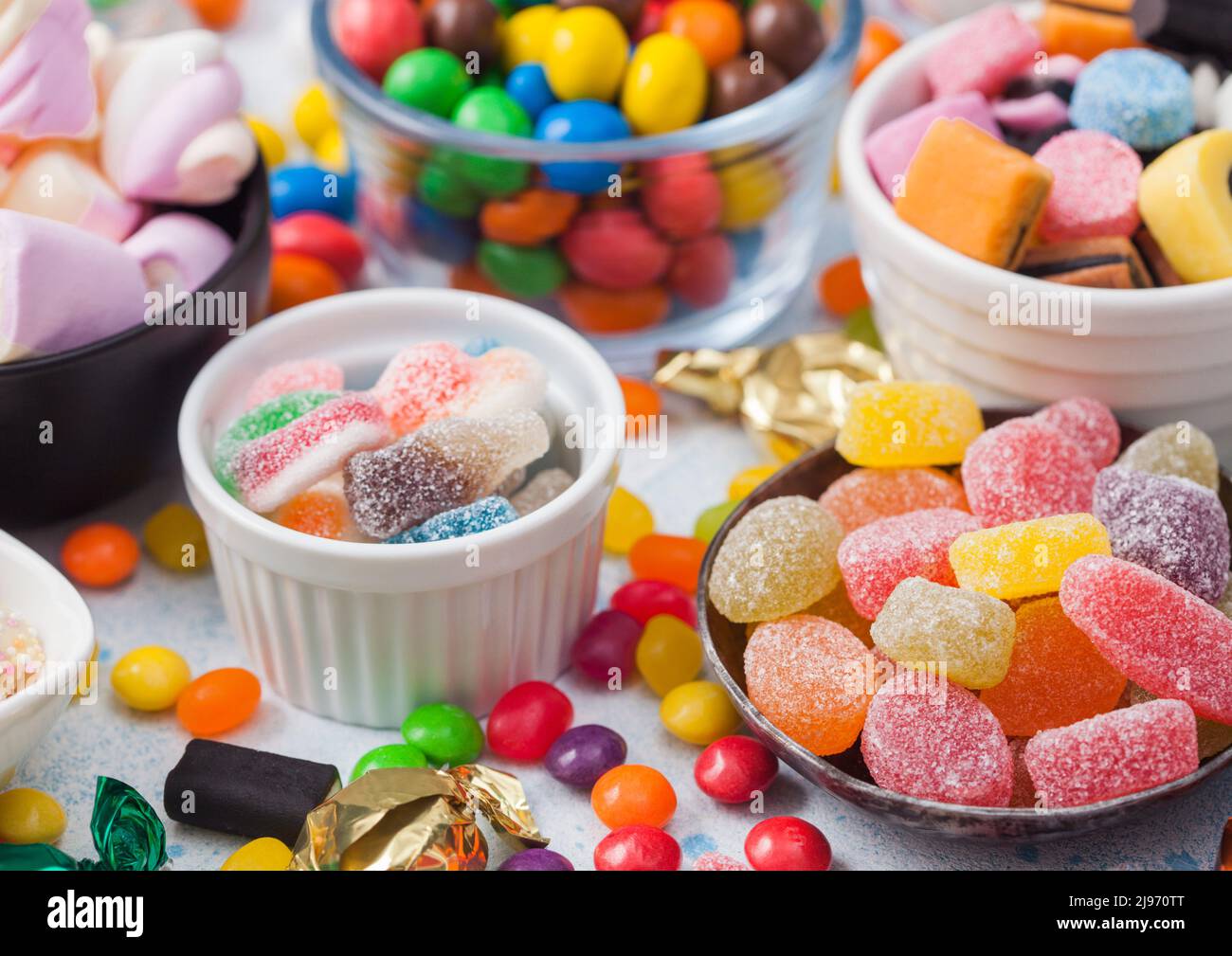 Jelly sugar gums candies on blue table with liquorice allsorts and ...