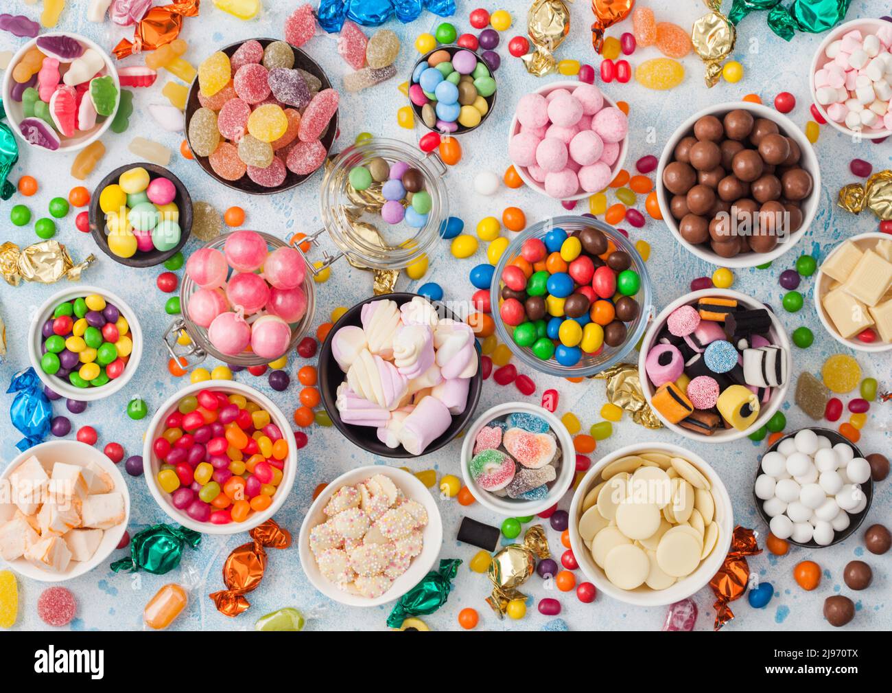 Milk chocolate and jelly gums candies on blue with liquorice allsorts ...