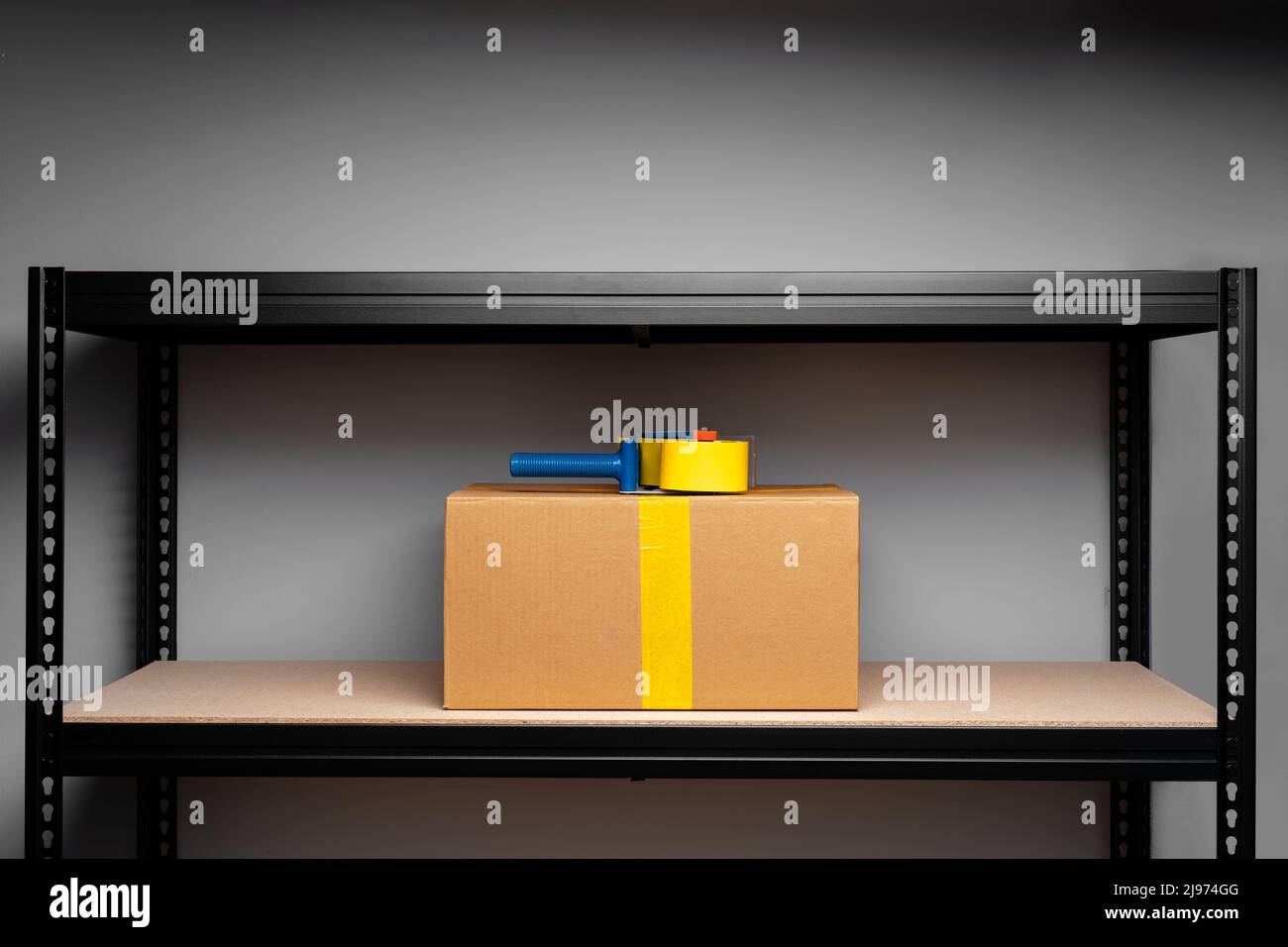 Stand shelf with one packed cardboard box Stock Photo - Alamy