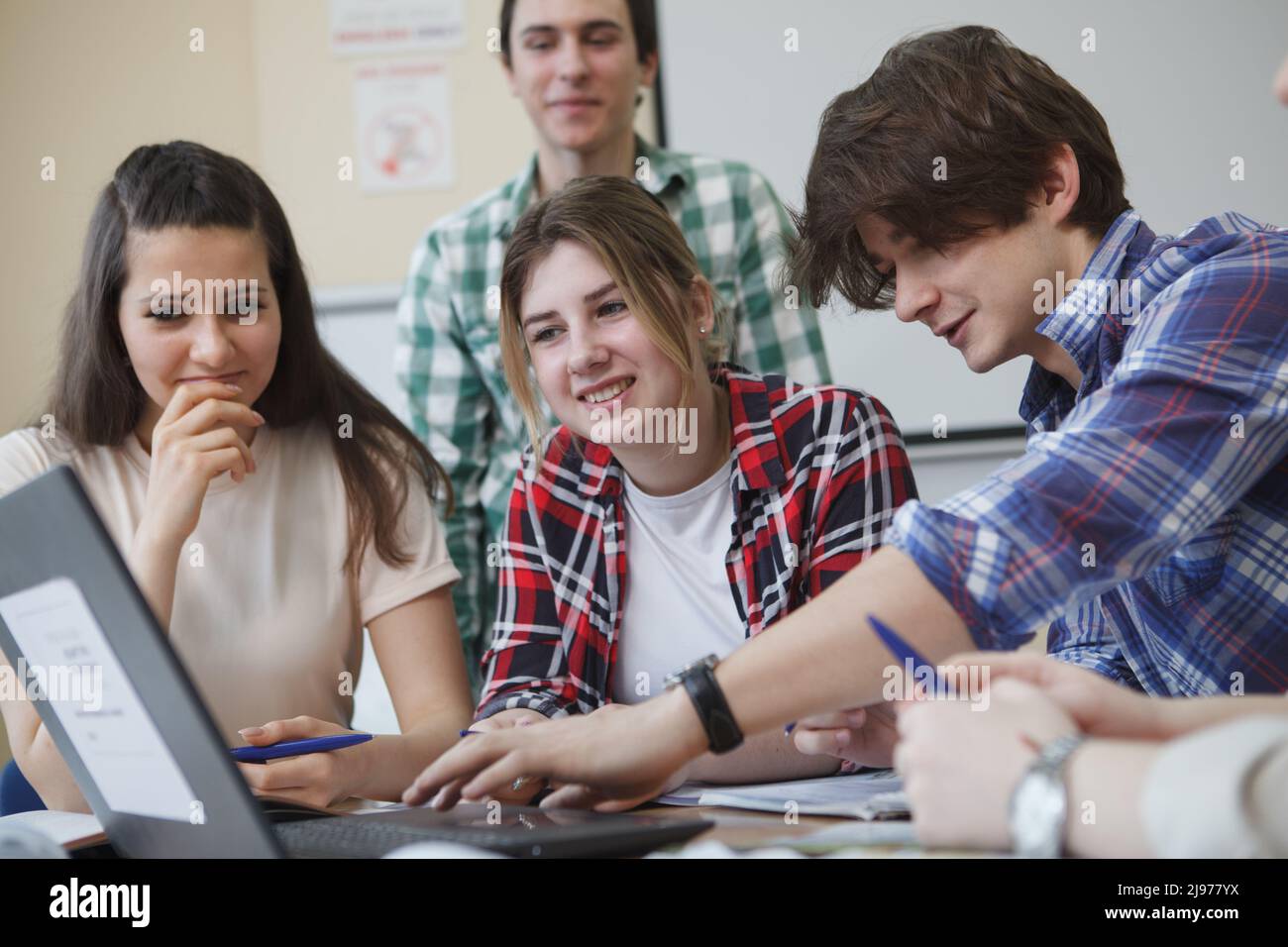 Happy young students smiling and talking while studying Stock Photo - Alamy