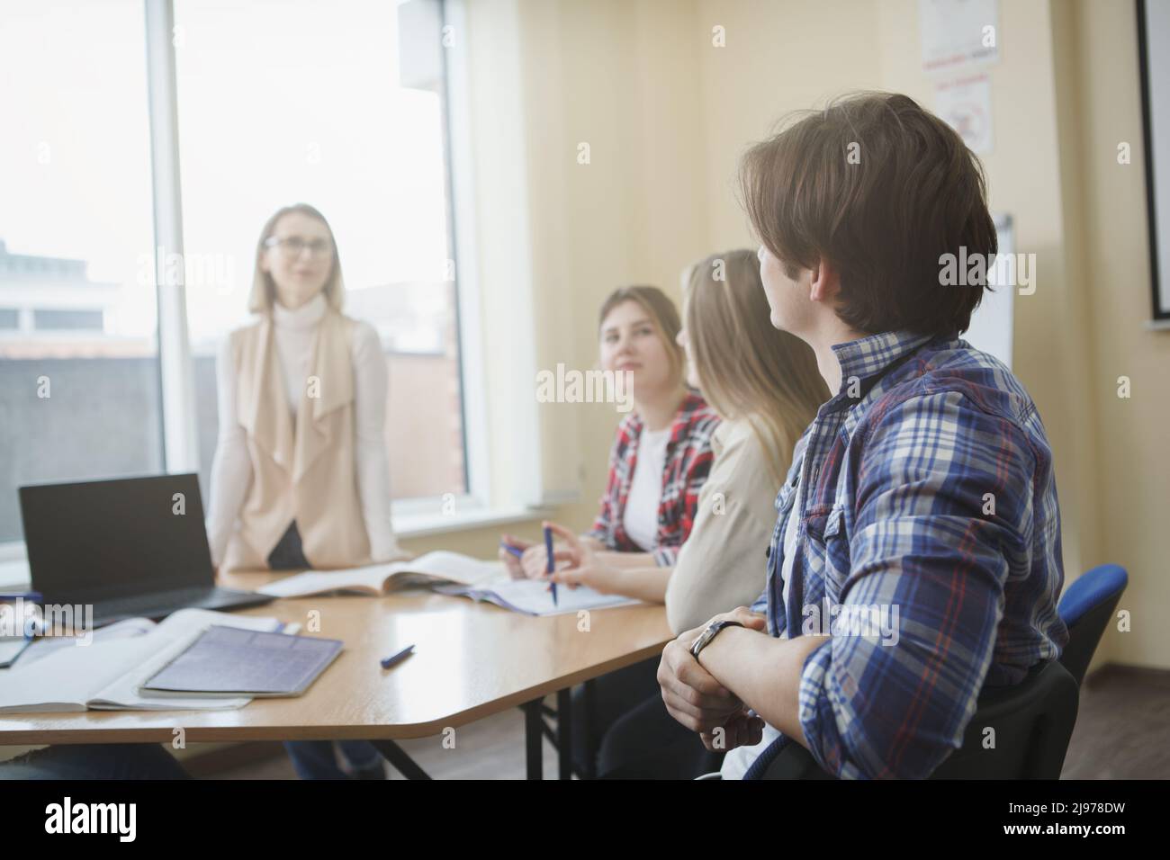 Male student sitting relaxed, enjoying seminar with university teacher ...
